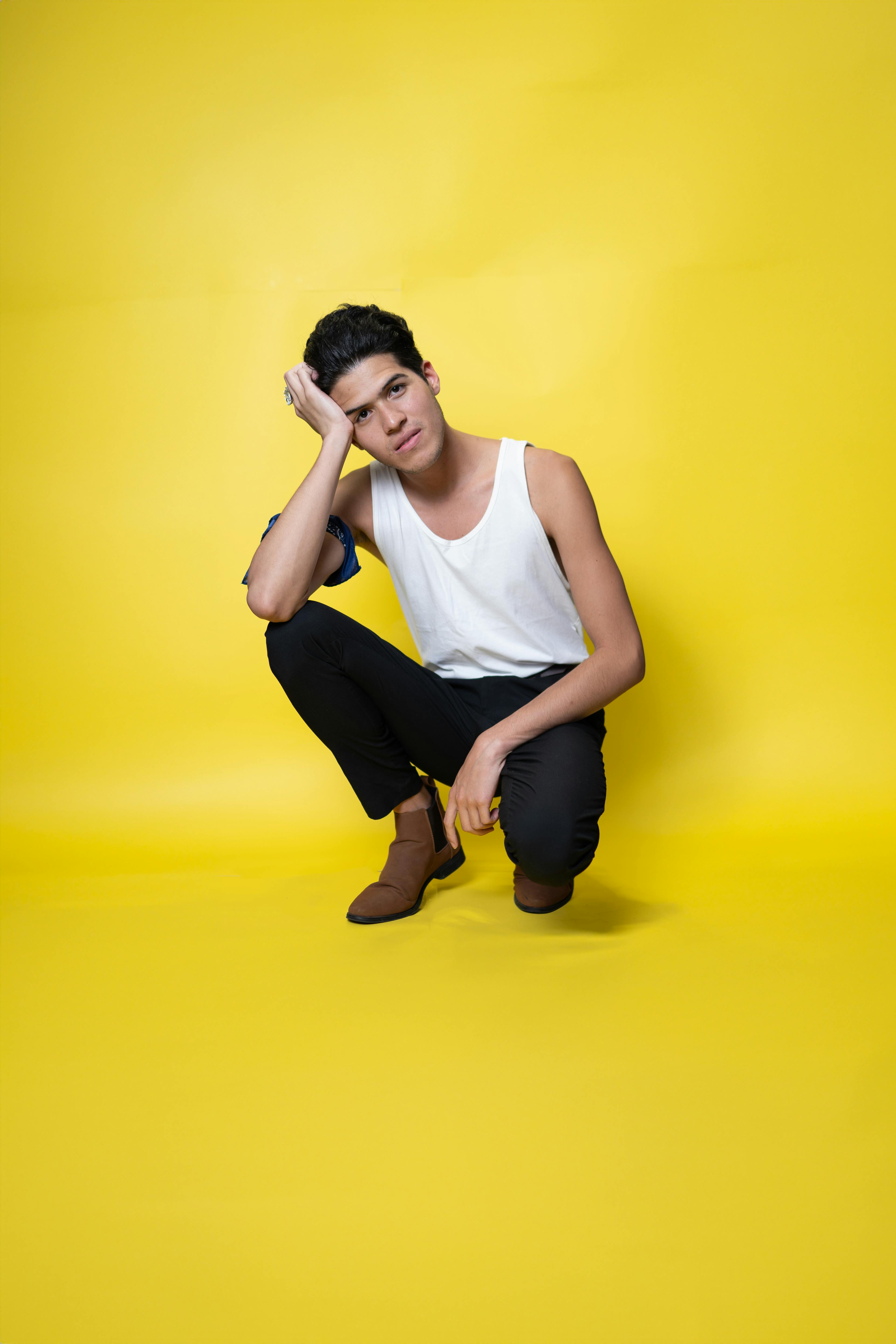 Young Man Posing on Yellow Studio Background · Free Stock Photo