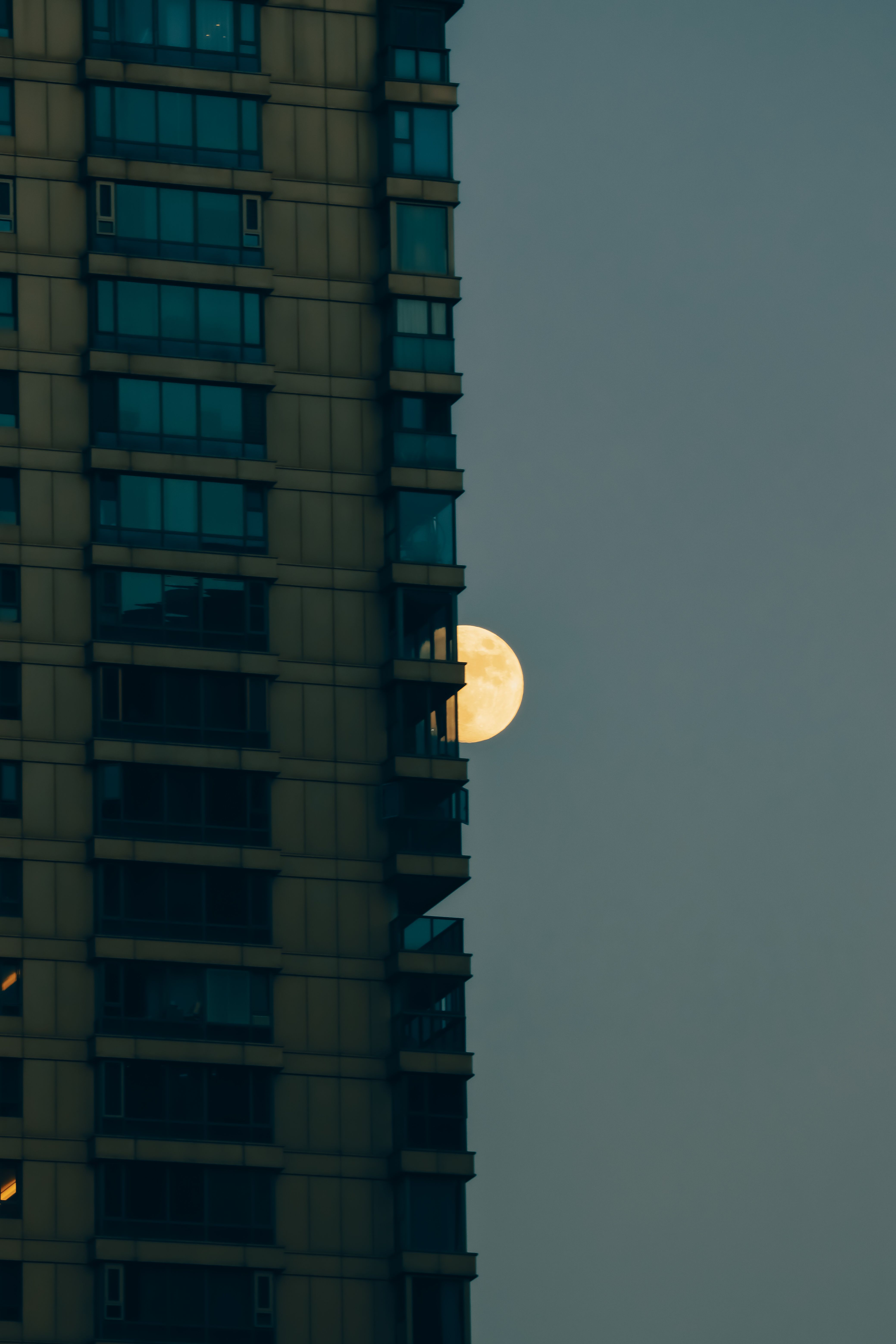 Full Moon Over White Concrete Building · Free Stock Photo
