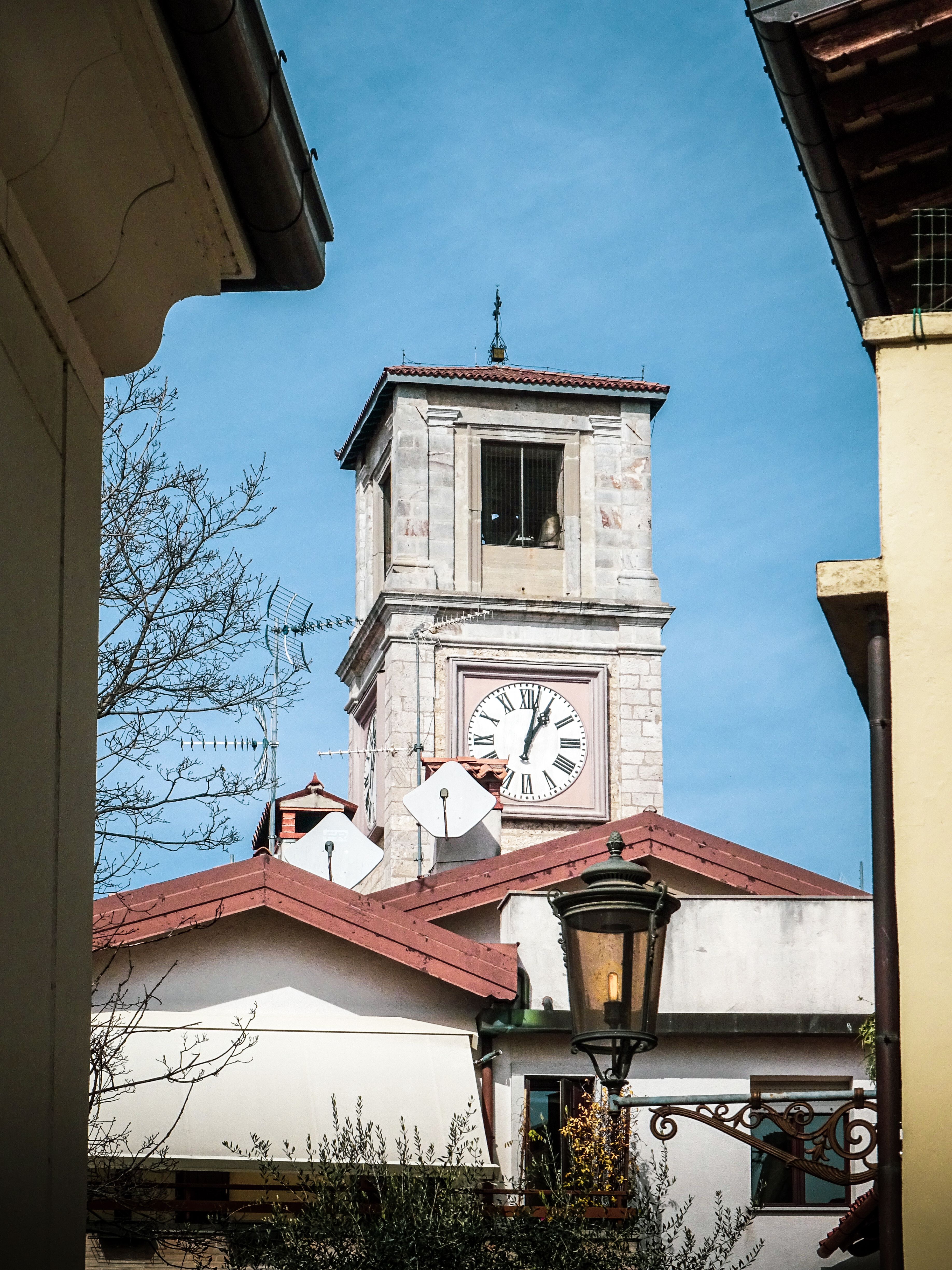 Clock Tower behind Buildings · Free Stock Photo