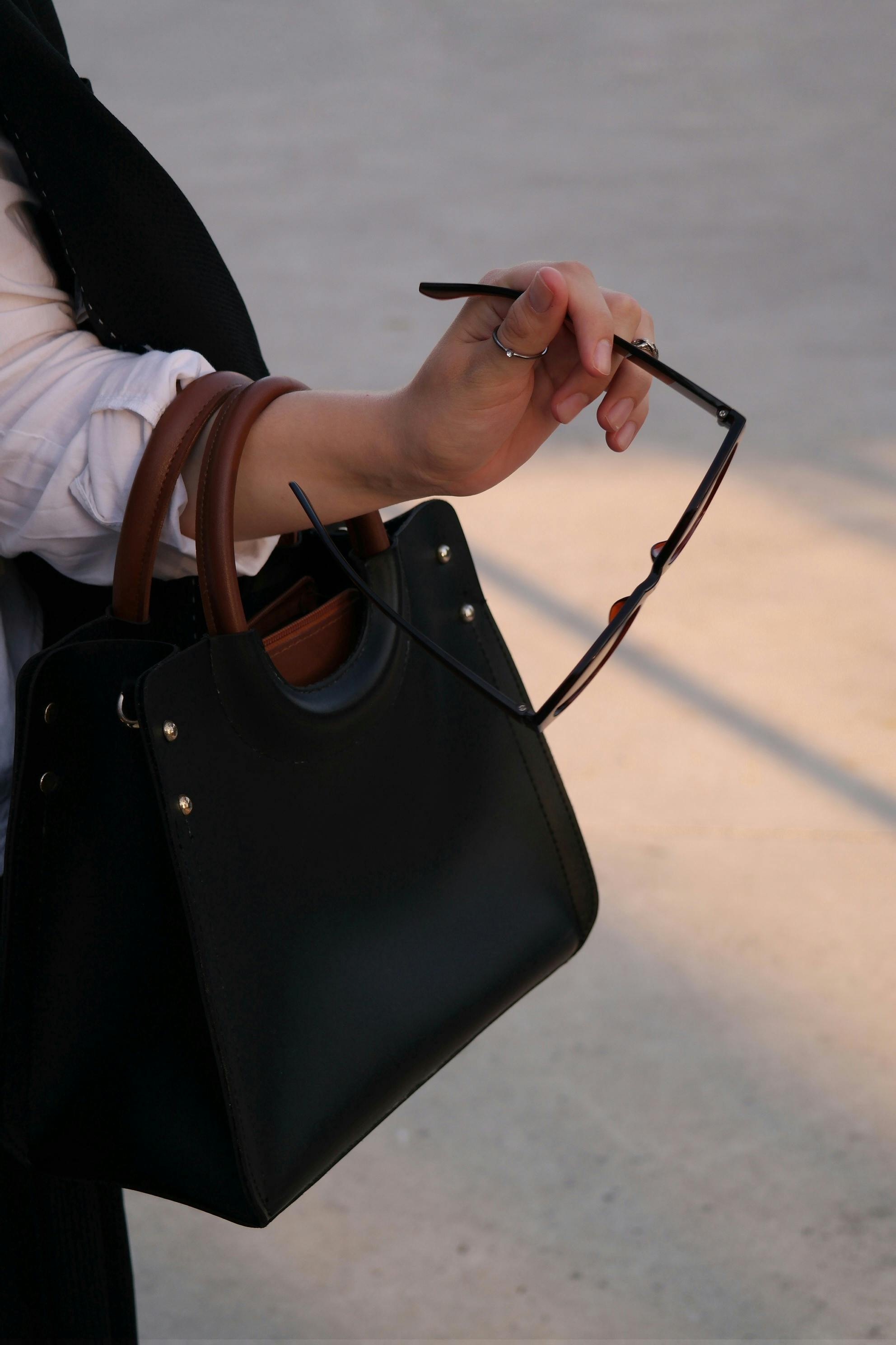 A Person Holding a Black Handbag · Free Stock Photo