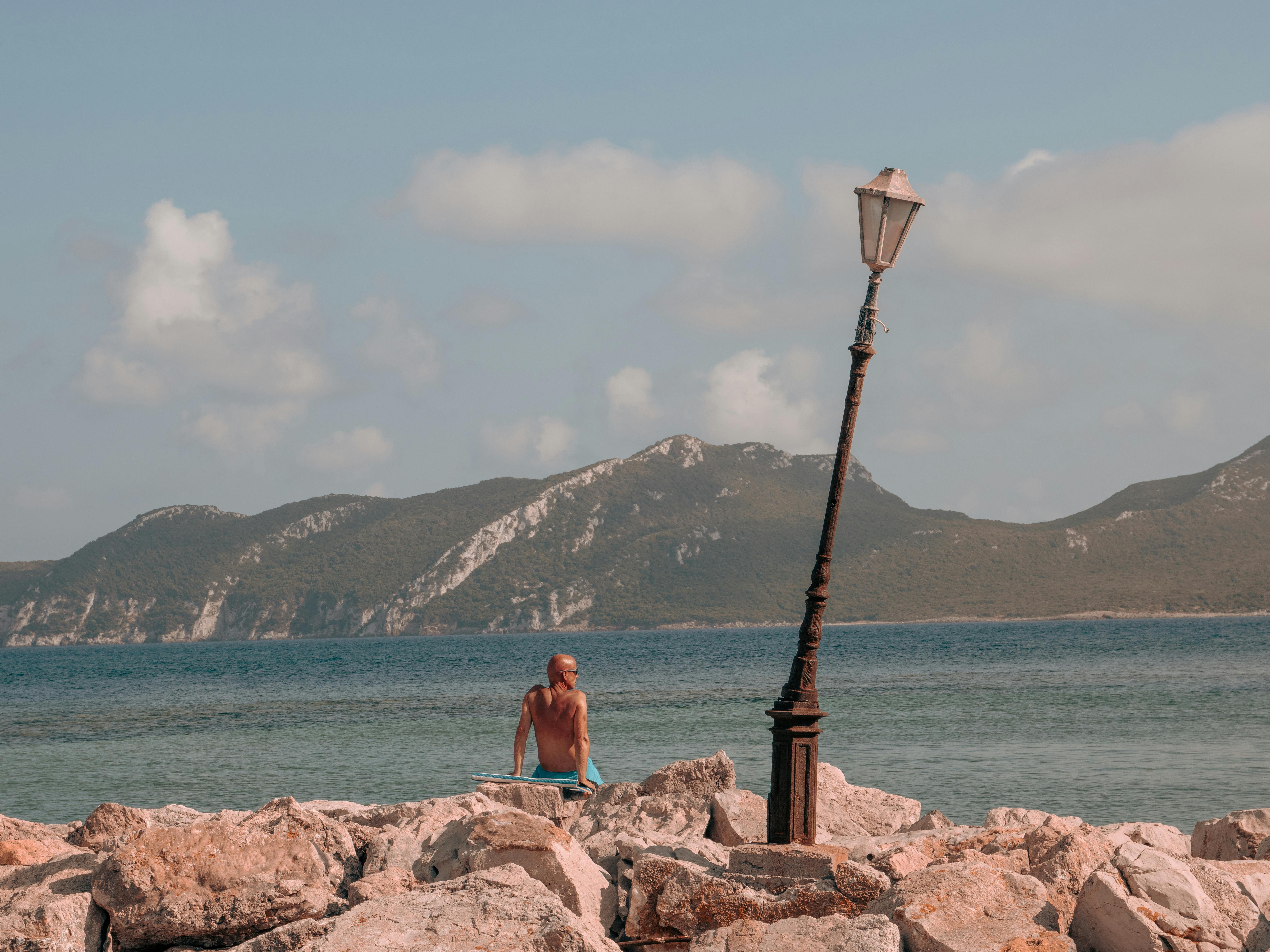 Bald Man on Rocky Beach · Free Stock Photo