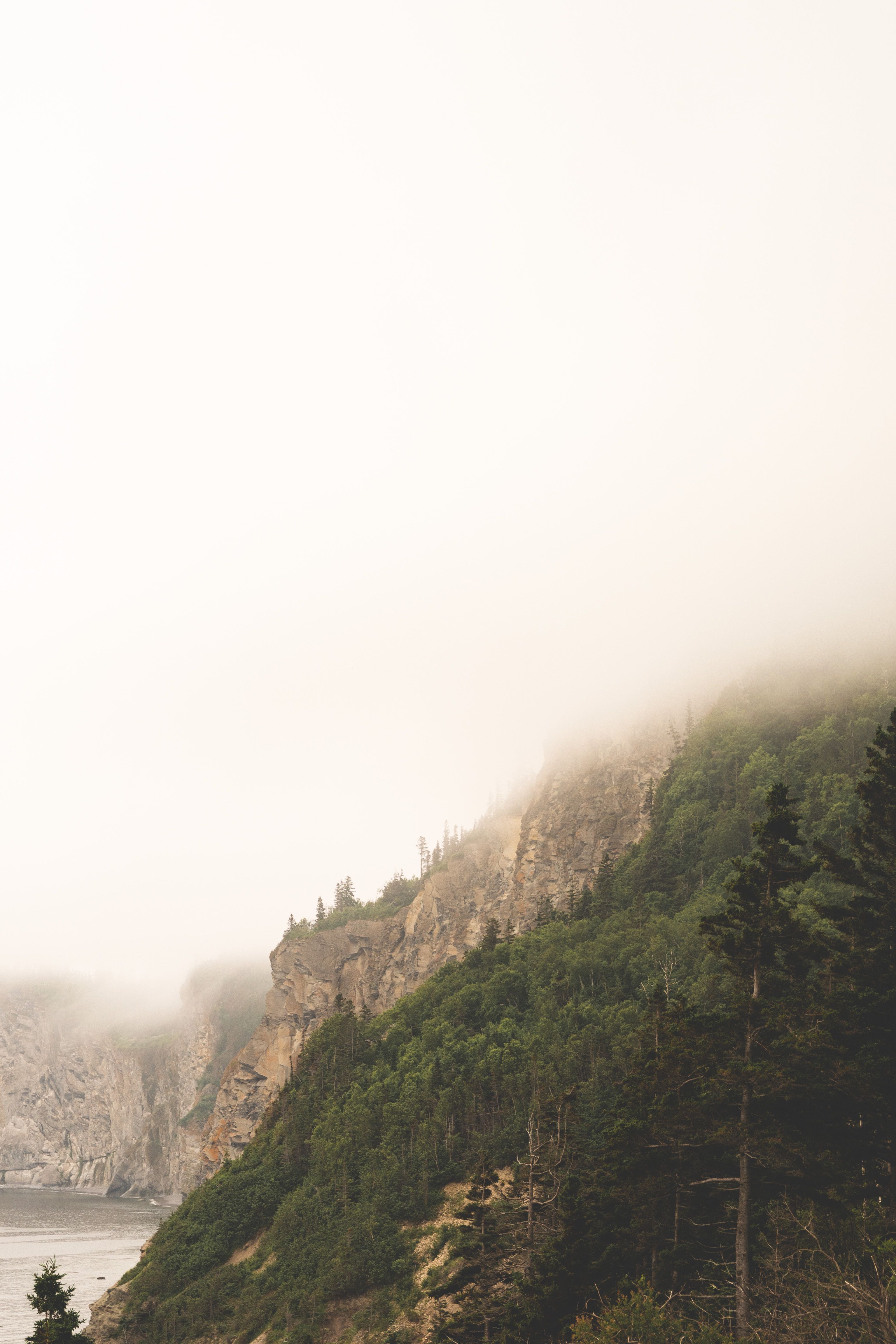 A foggy view of a cliff and water · Free Stock Photo