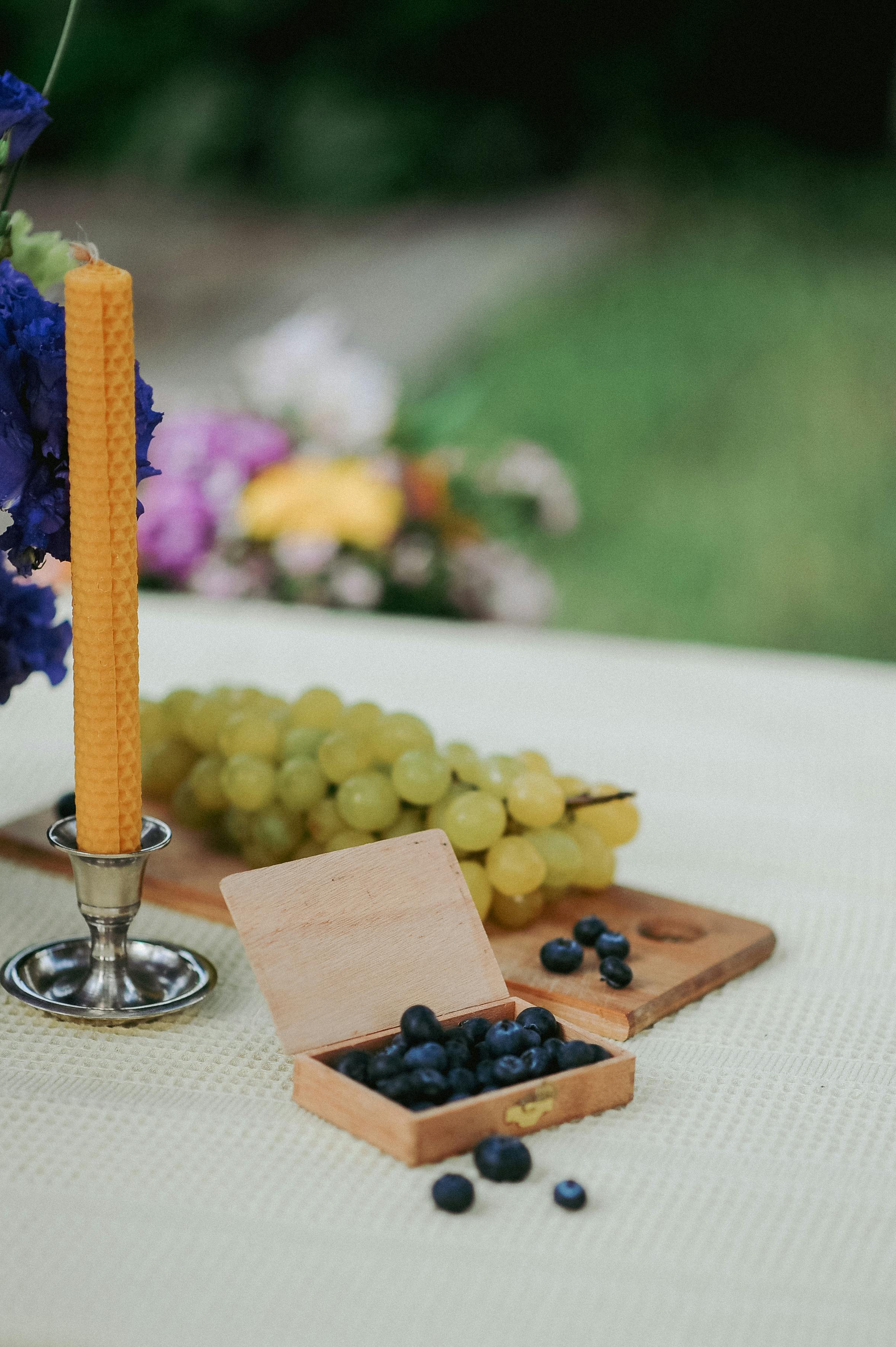 Fruit and a Candlestick on the Table in the Garden · Free Stock Photo