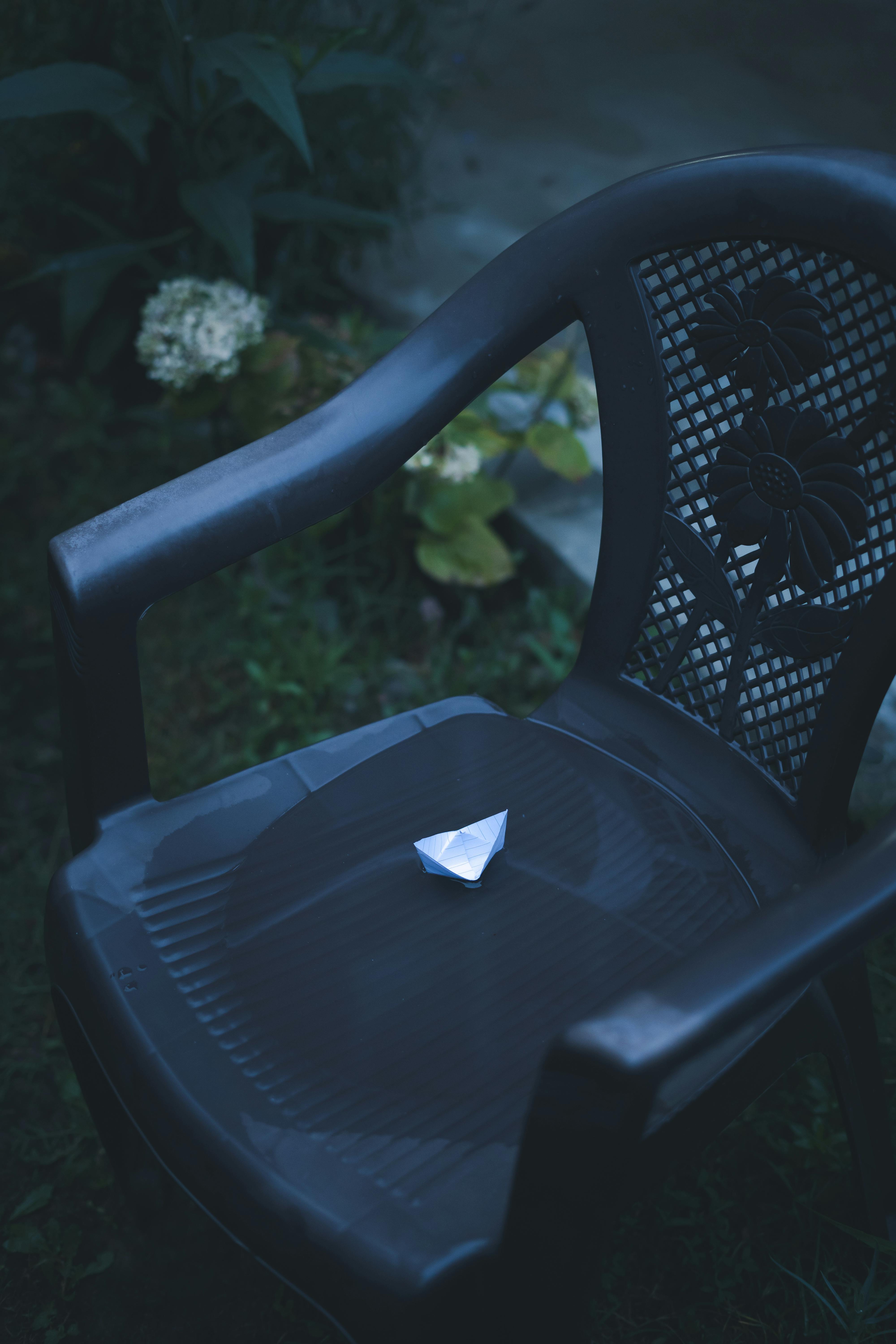 Paper Boat on Puddle on Plastic Chair · Free Stock Photo