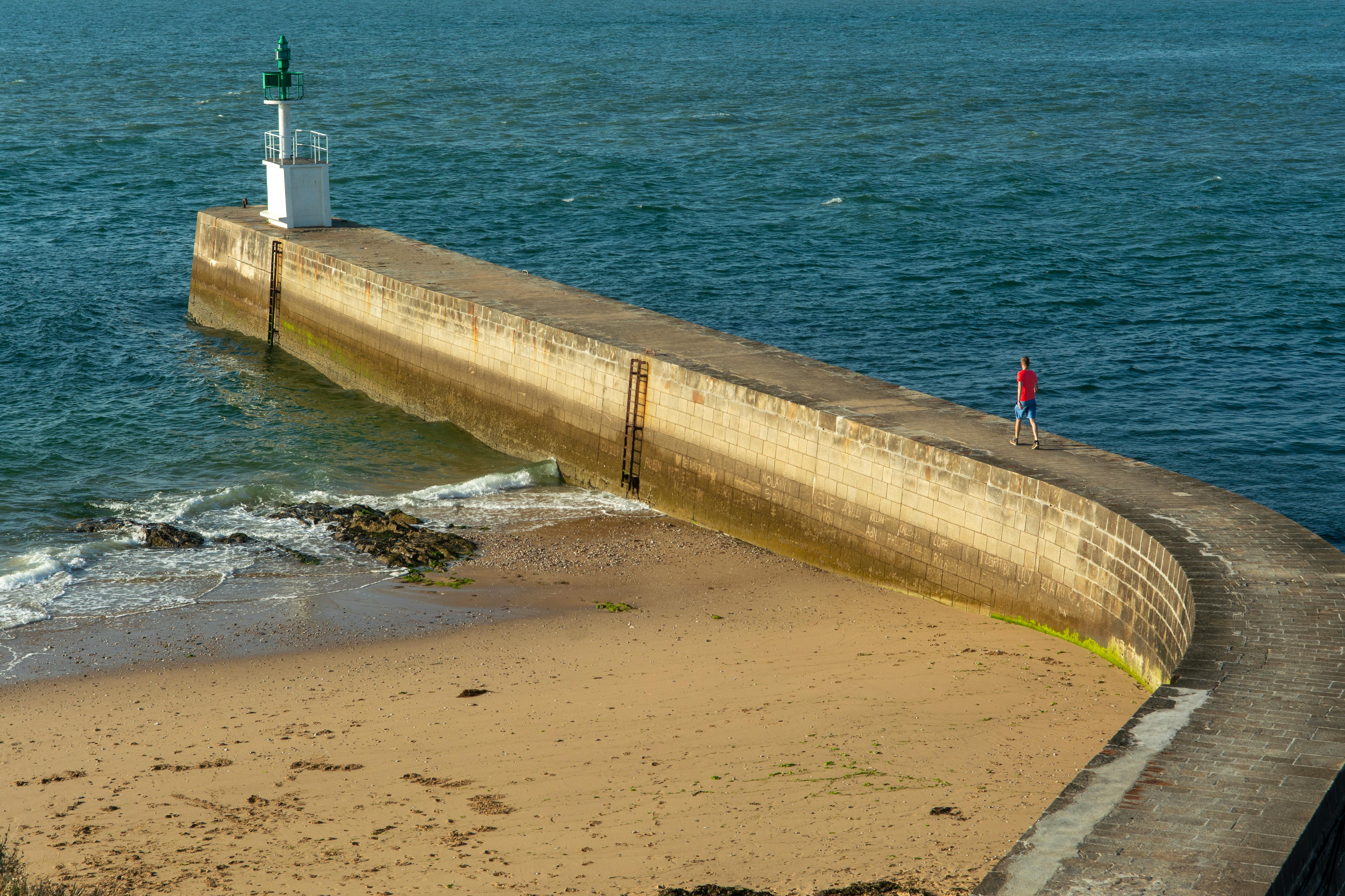 Aerial View of a Man Walking Toward the Lighthouse · Free Stock Photo