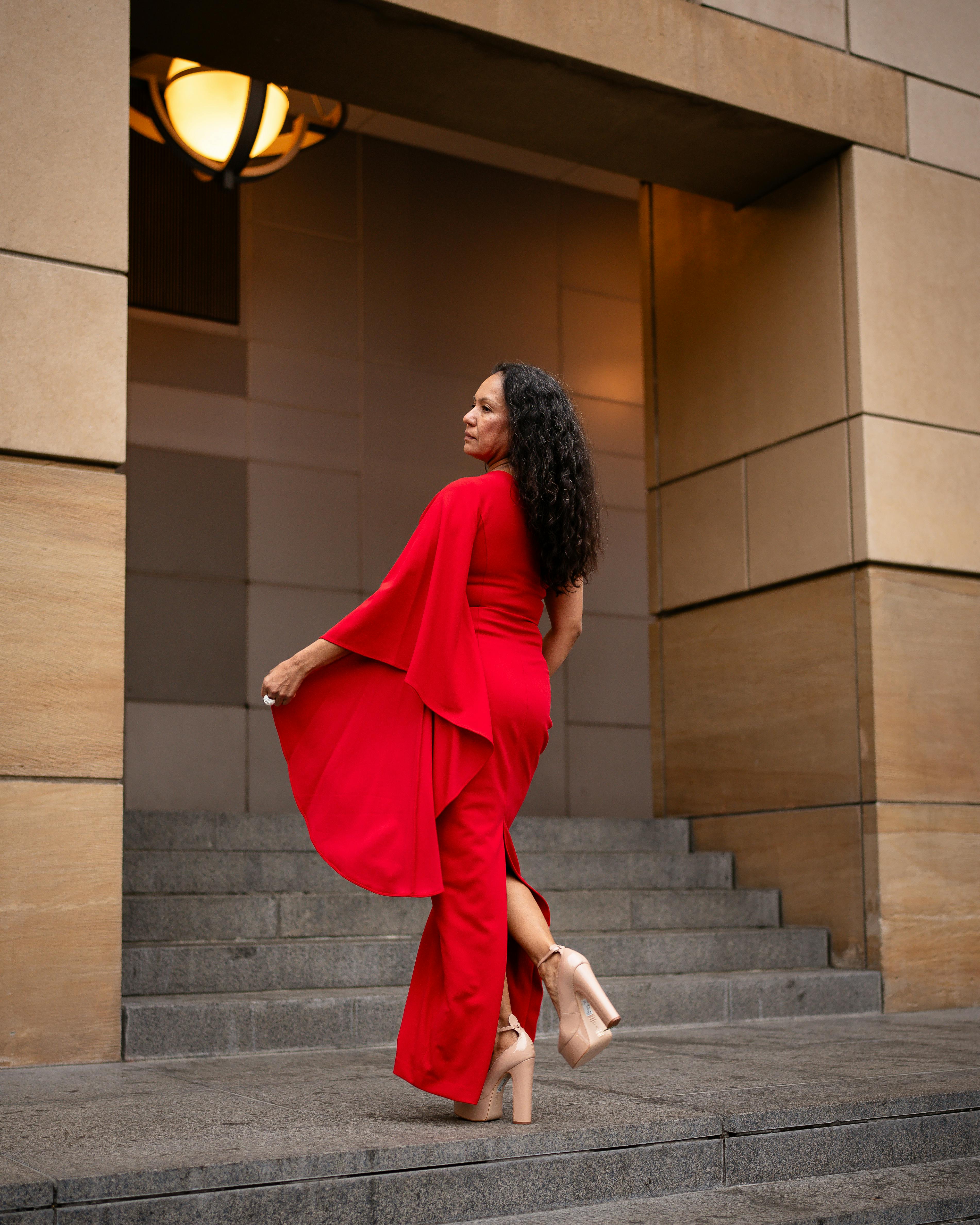 An Elegant Woman in a Red Dress and Heels Standing on the Steps · Free ...