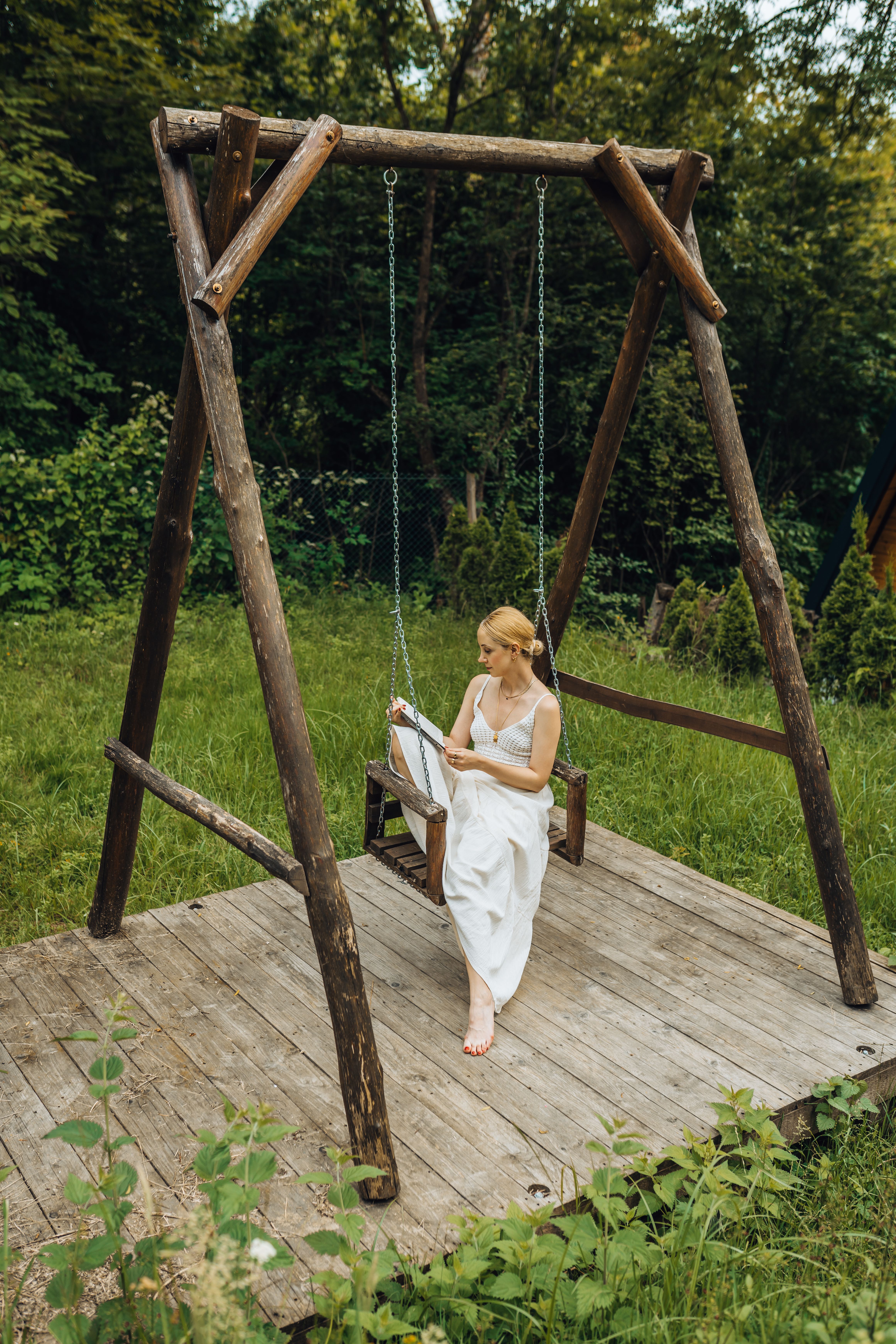 Young Woman Sitting on a Swing and Reading a Book · Free Stock Photo