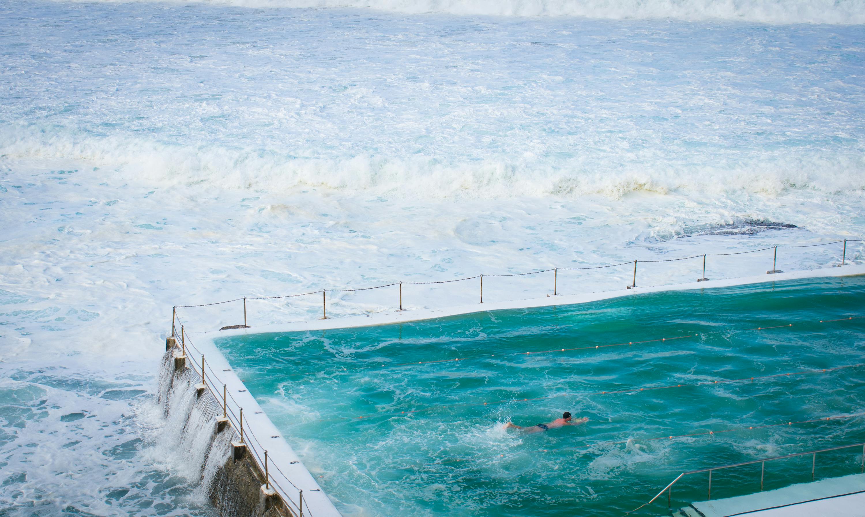 Person Swimming on Pool Beside Ocean · Free Stock Photo