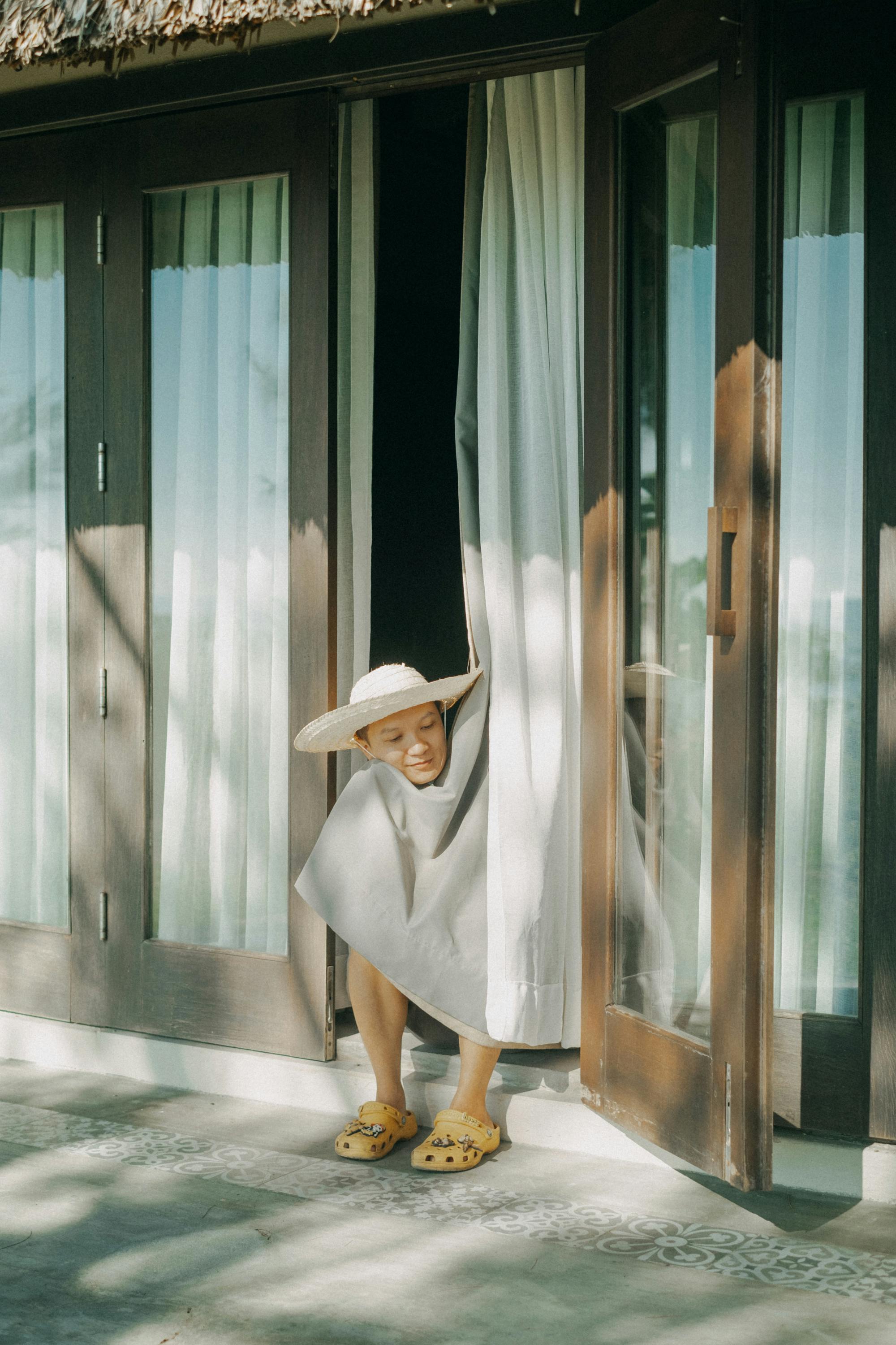 Boy Sitting under Curtain in Dooryard · Free Stock Photo