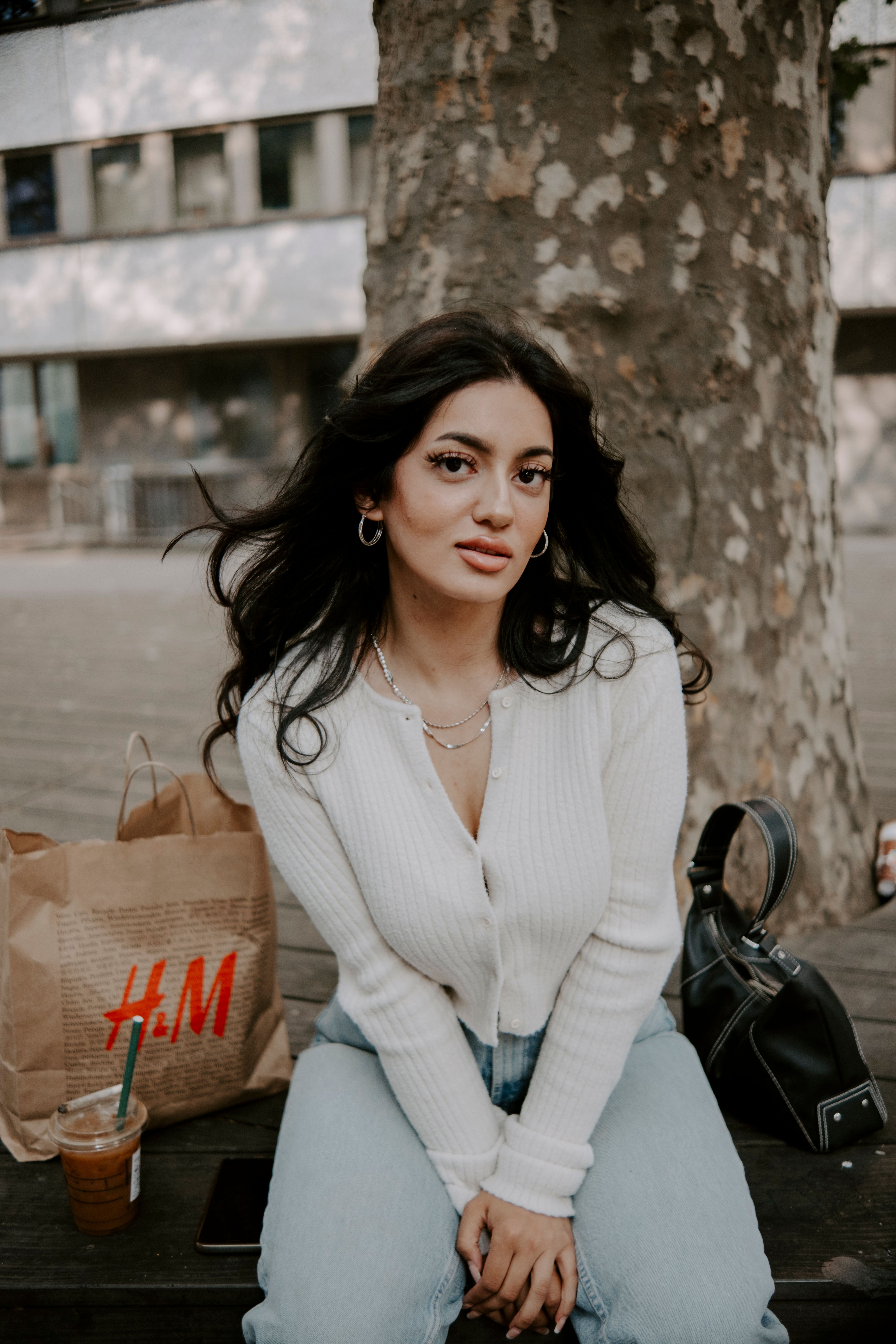 Woman in a White Cardigan Sitting on a Bench · Free Stock Photo