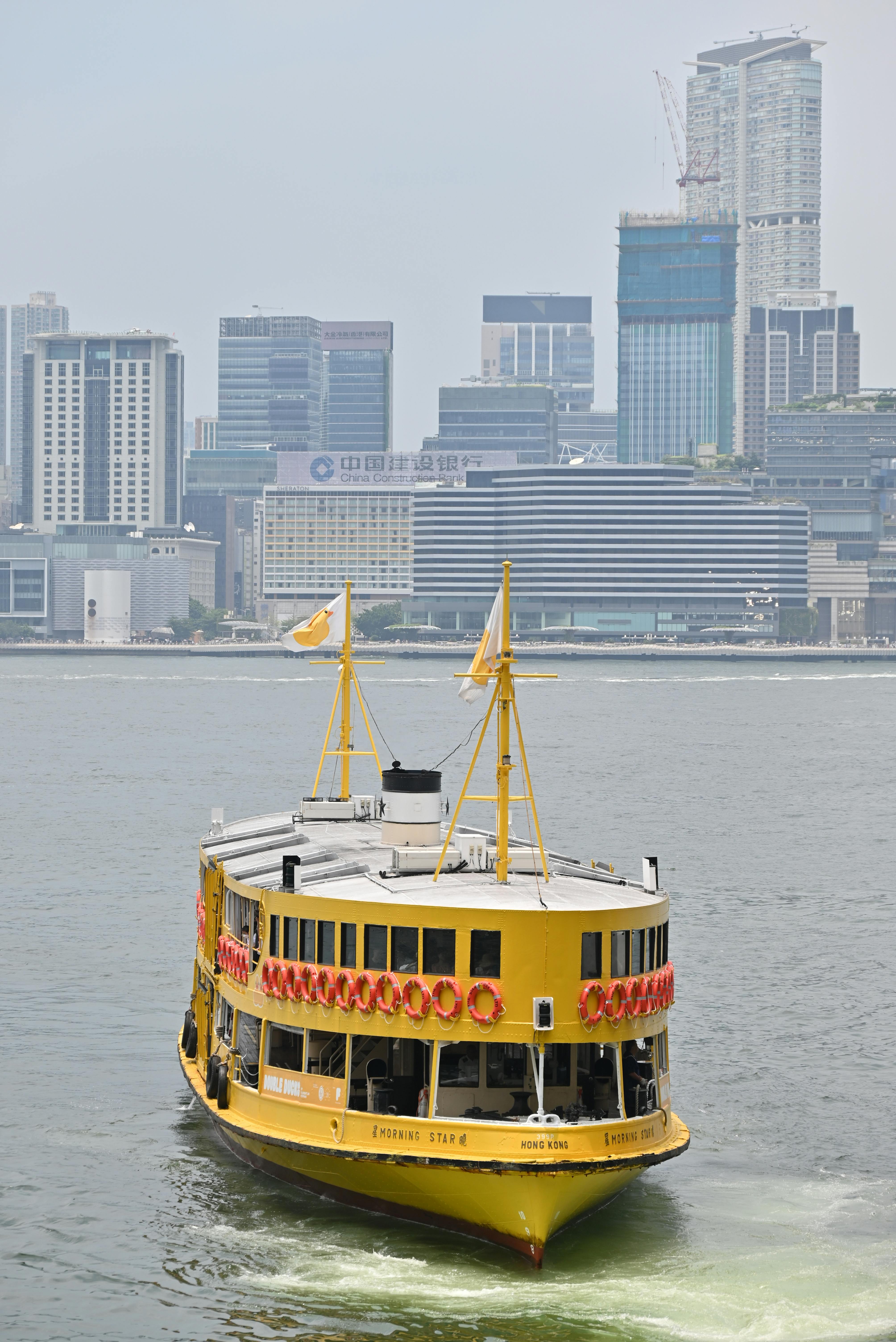 Yellow Ferry Sailing in Hong Kong Harbor with City Skyline in the ...