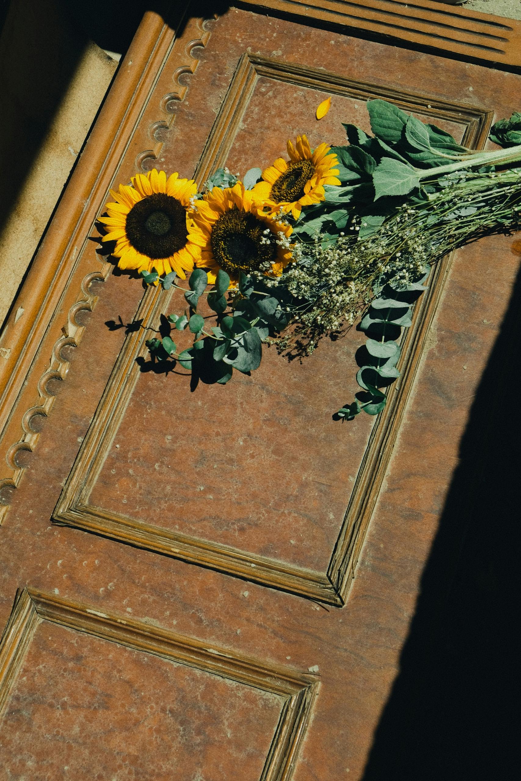 Bouquet of Sunflowers Lying on Crypt Doors · Free Stock Photo