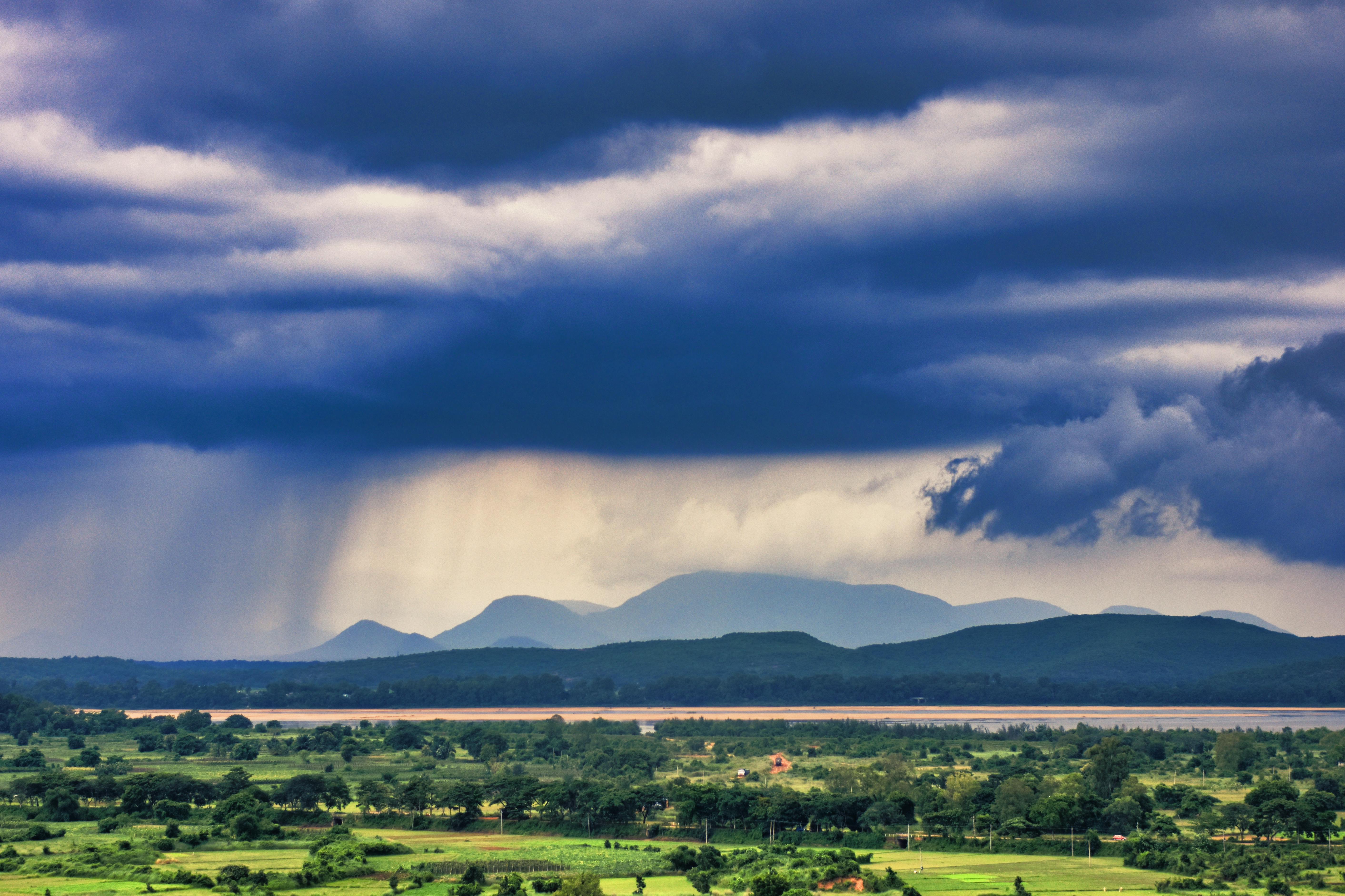 Rain Clouds over a Countryside Landscape with Distant Mountains · Free ...