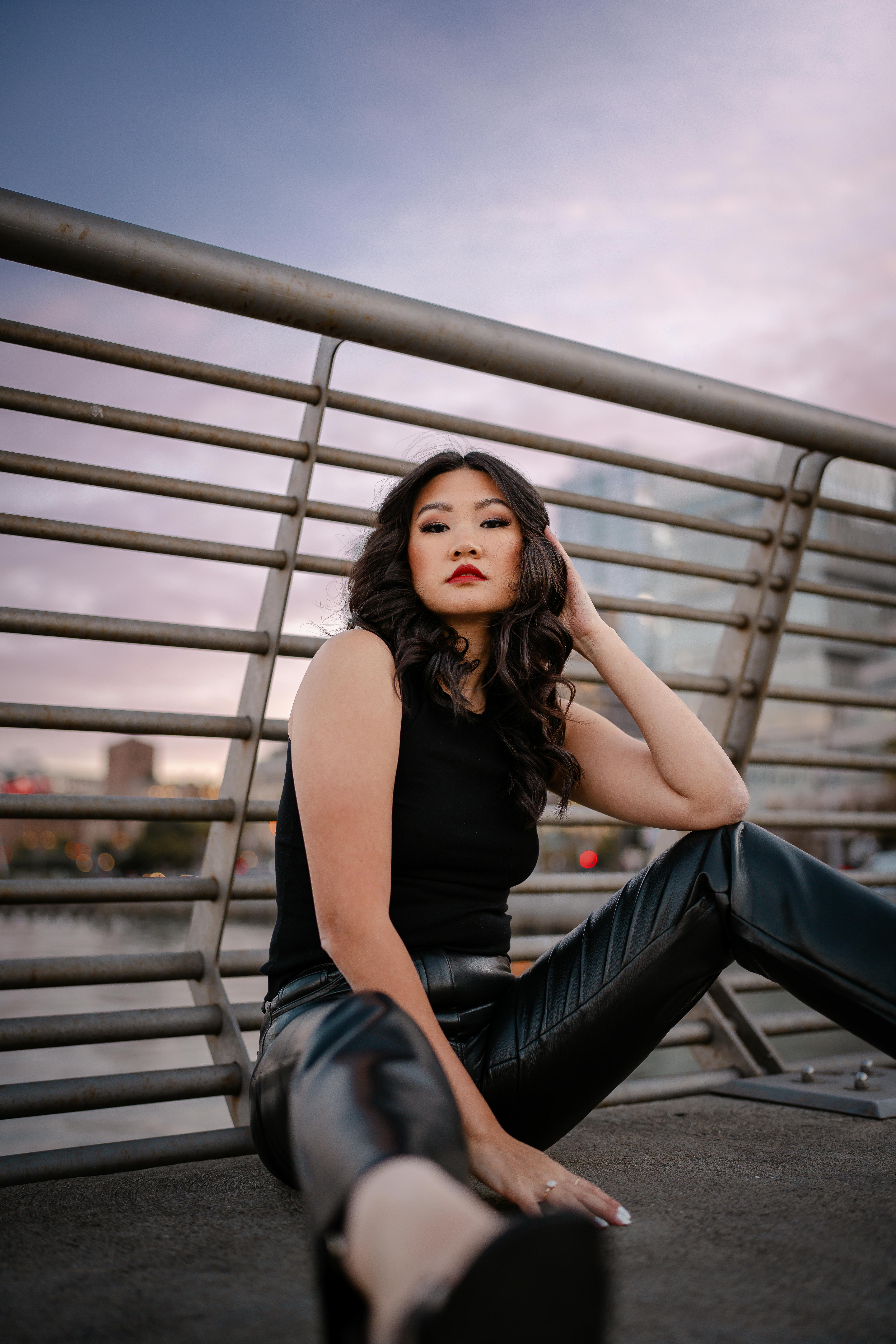 Woman Sitting and Posing by Railing · Free Stock Photo