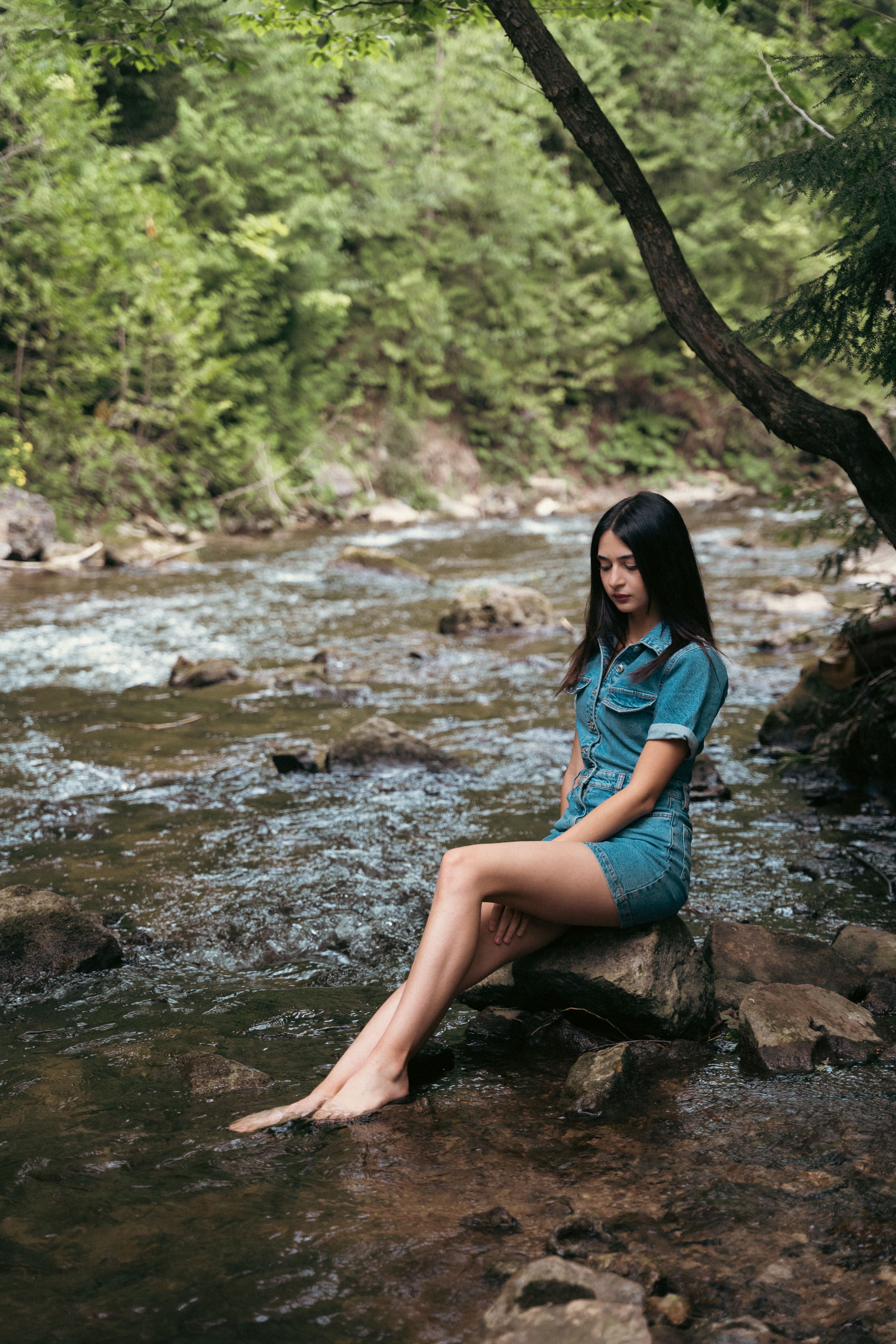Brunette Woman Sitting on Rock on Stream · Free Stock Photo