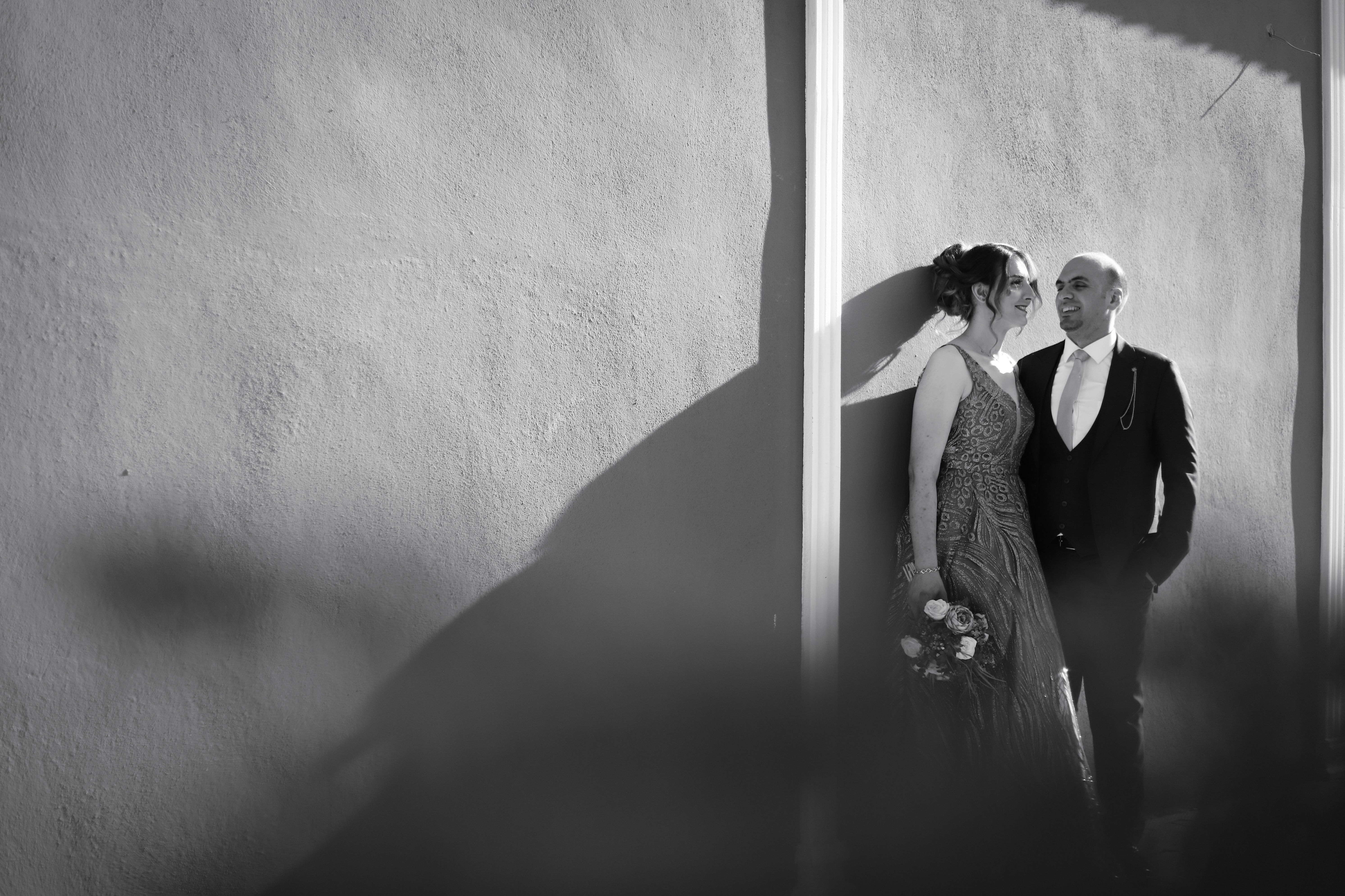 Couple Standing Together by Wall · Free Stock Photo
