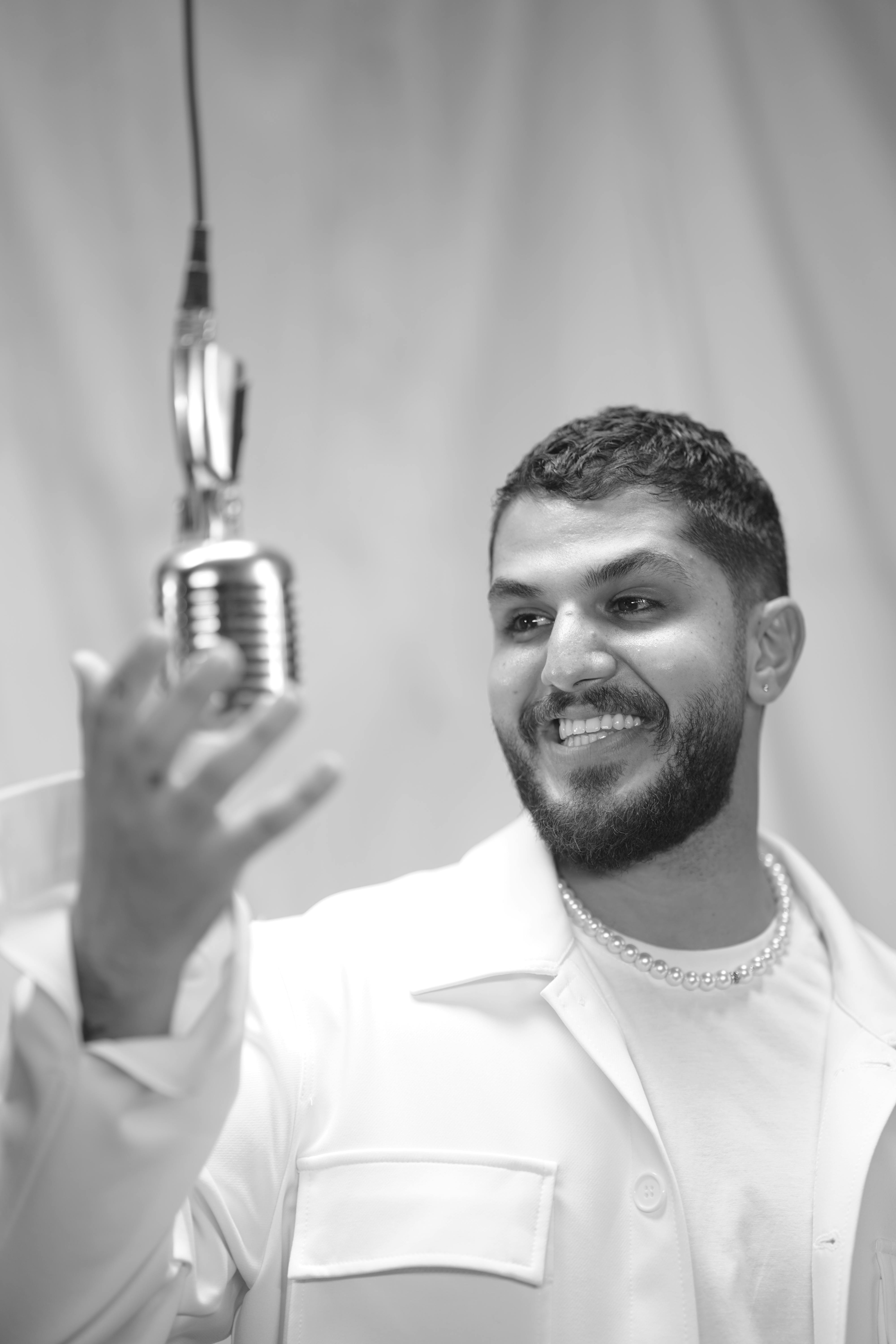 Smiling Singer Holding Microphone · Free Stock Photo