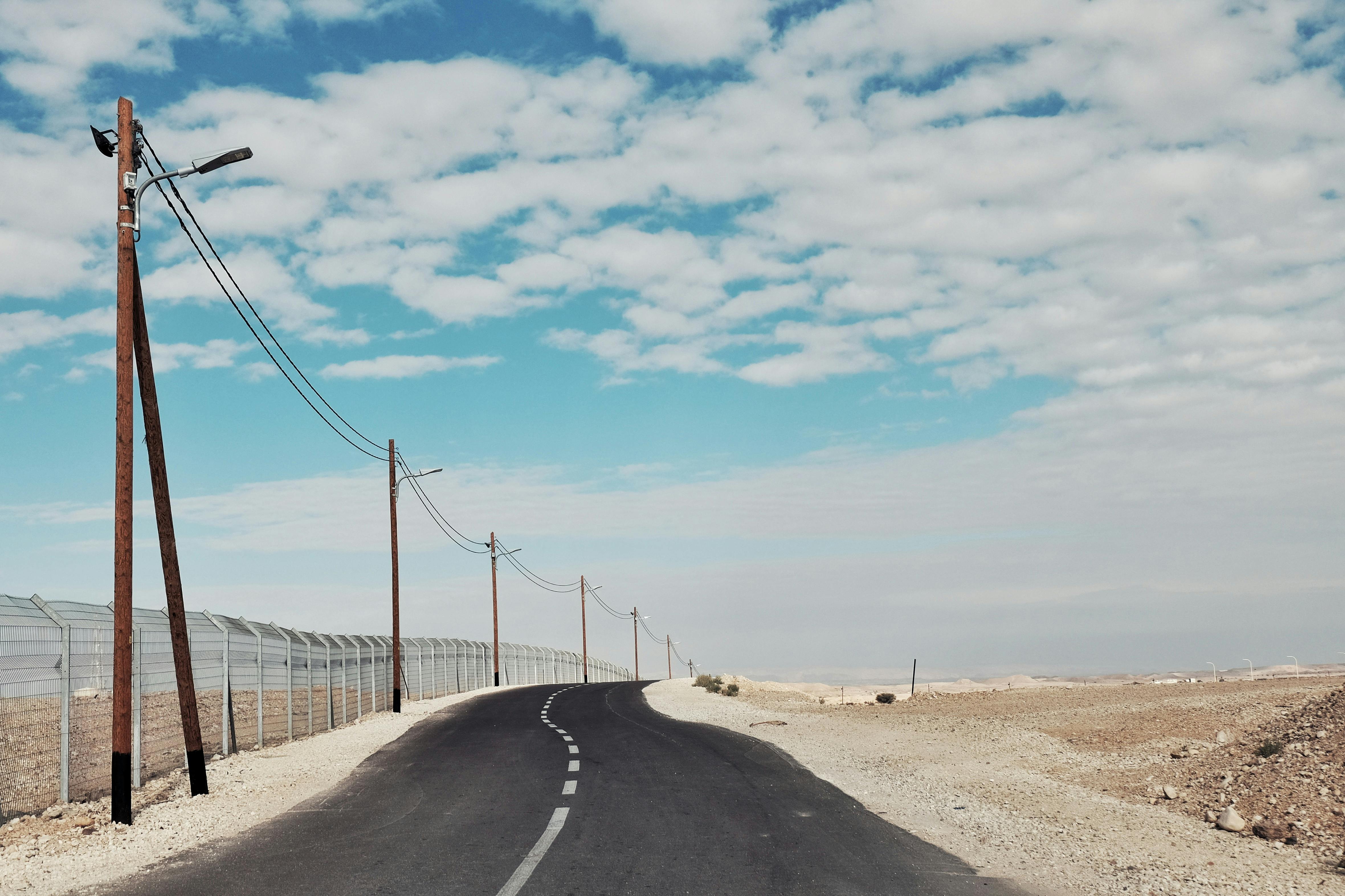 Fence and Utility Poles near Road · Free Stock Photo