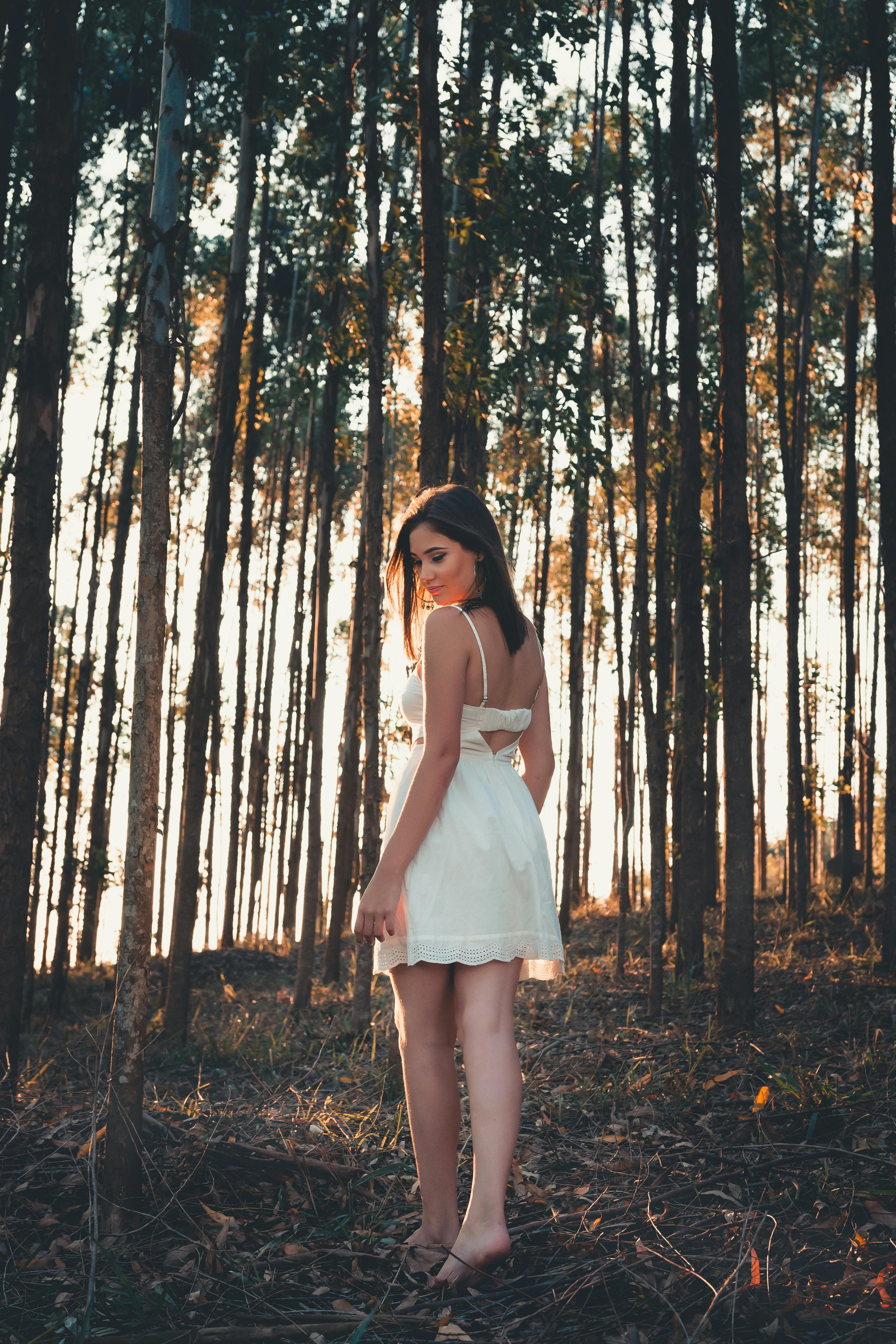 Woman Standing Behind Trees · Free Stock Photo