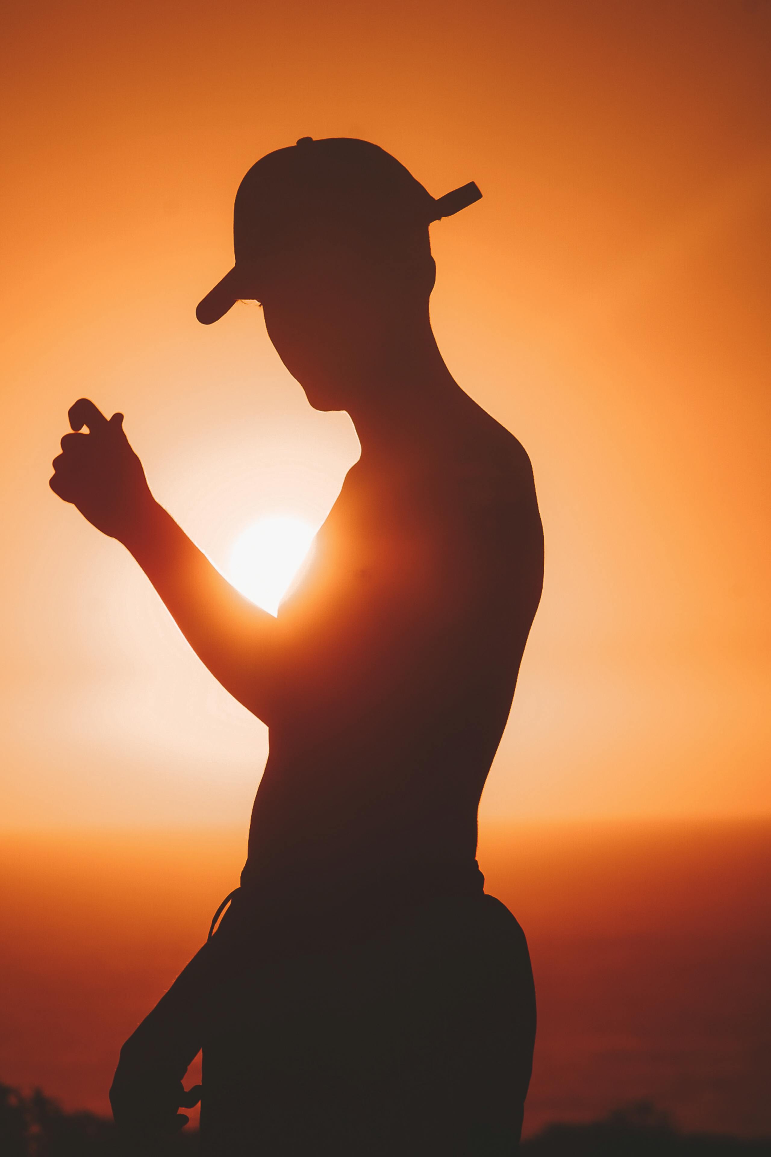 Silhouette of Man in Hat at Sunset · Free Stock Photo