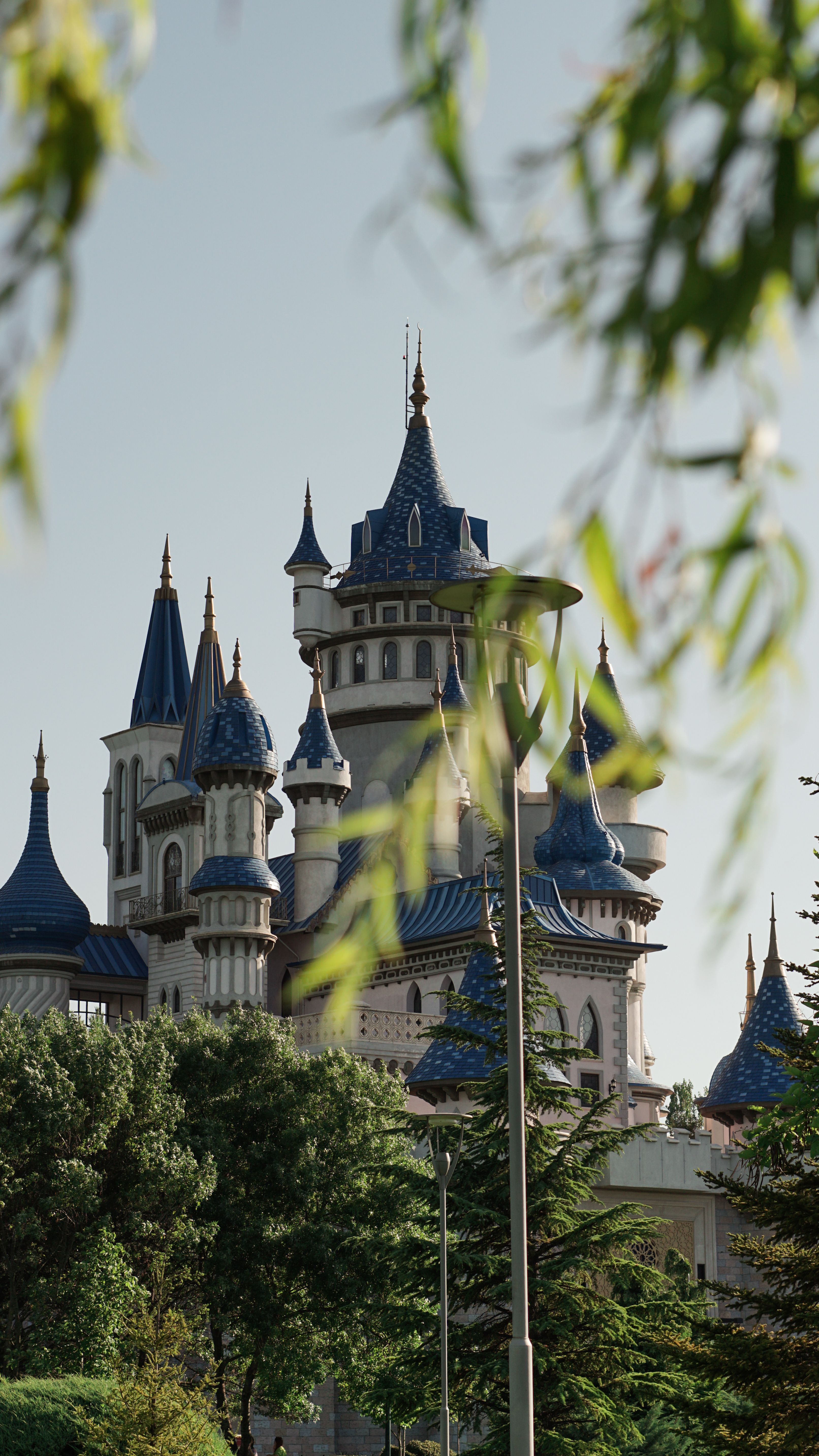 A castle is surrounded by trees and bushes · Free Stock Photo