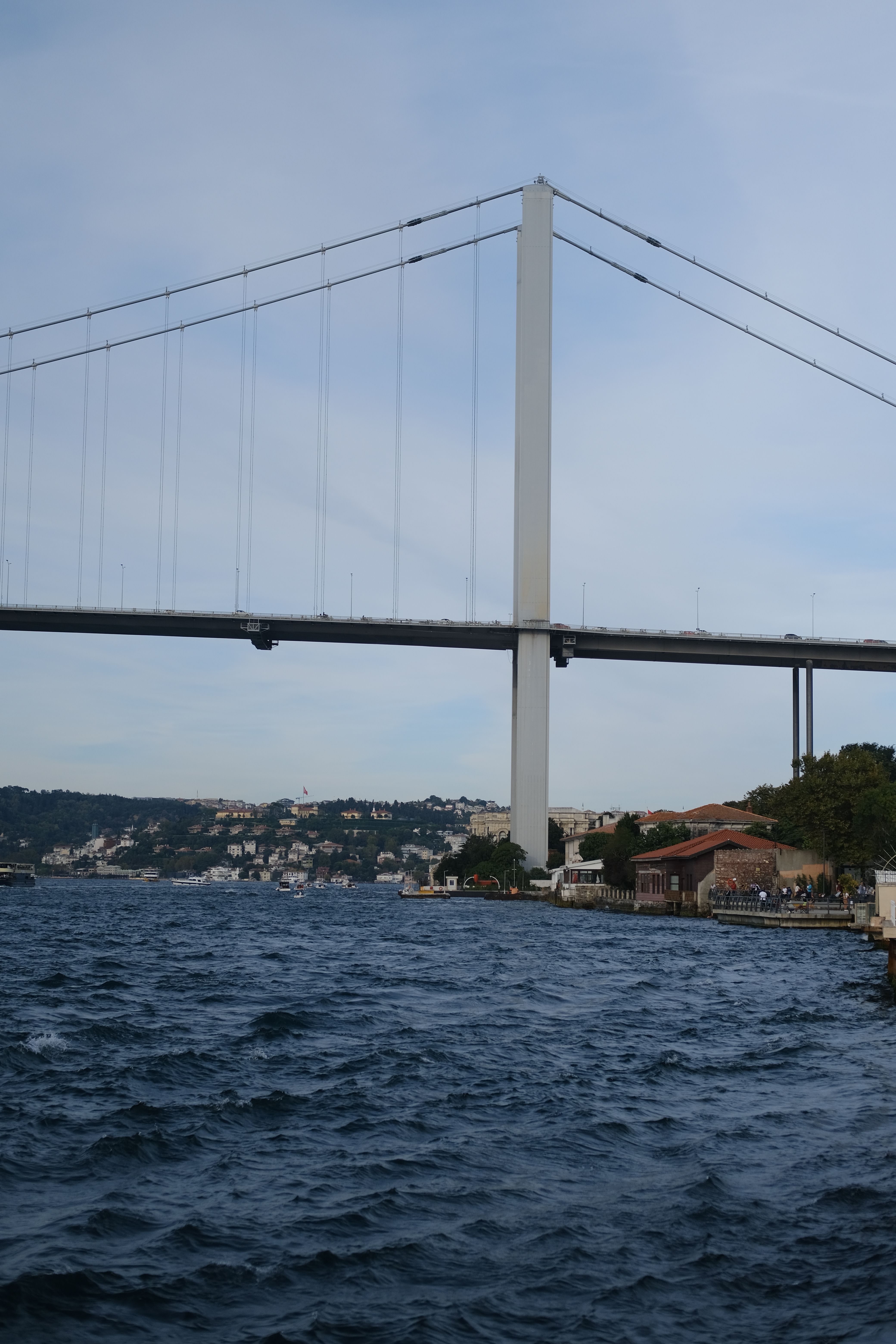 A large bridge spanning over water with a boat in the background · Free ...