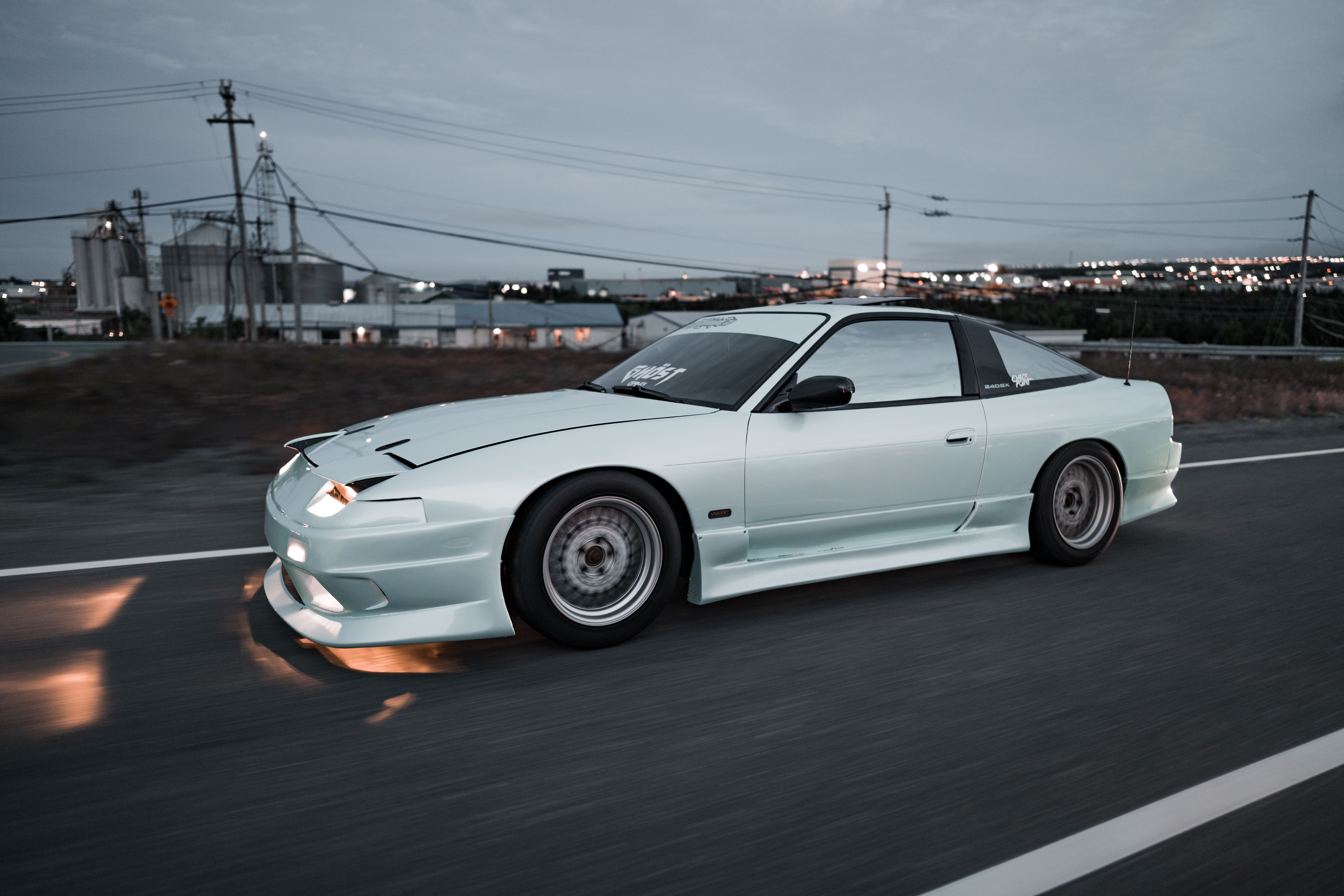 A light blue car driving down the road · Free Stock Photo