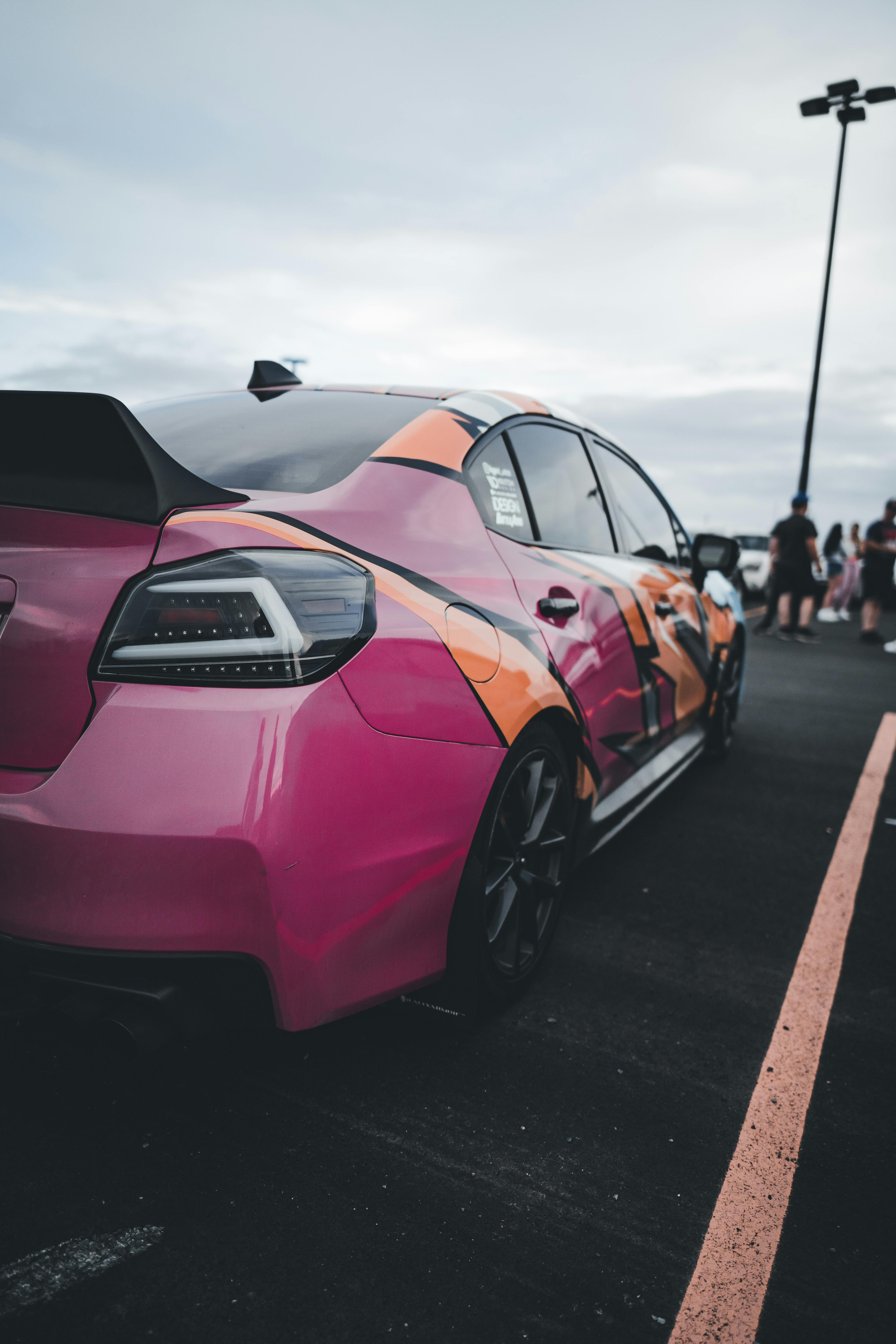 A pink car with a pink and orange paint job · Free Stock Photo