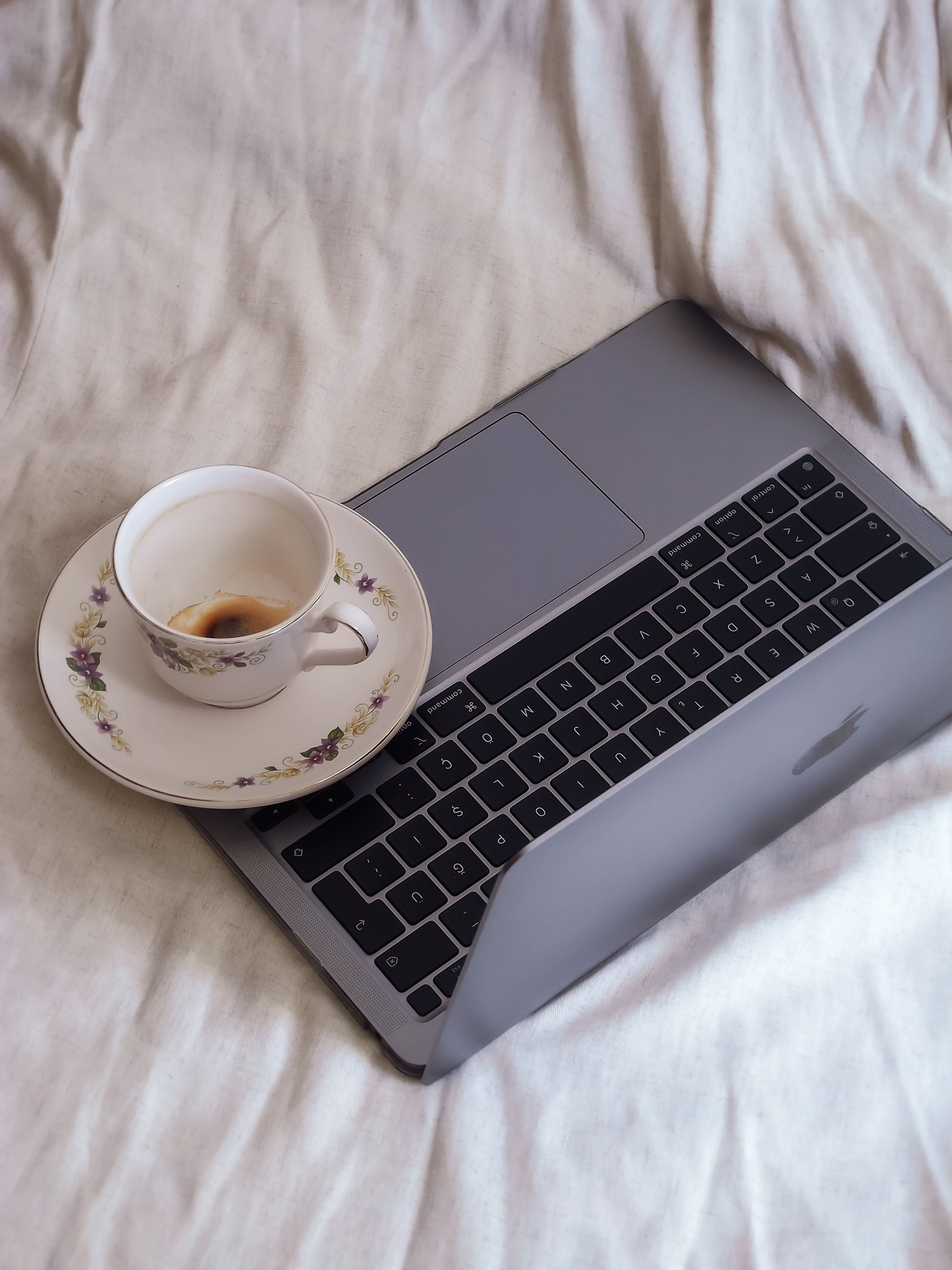A laptop and a cup of coffee on a bed · Free Stock Photo