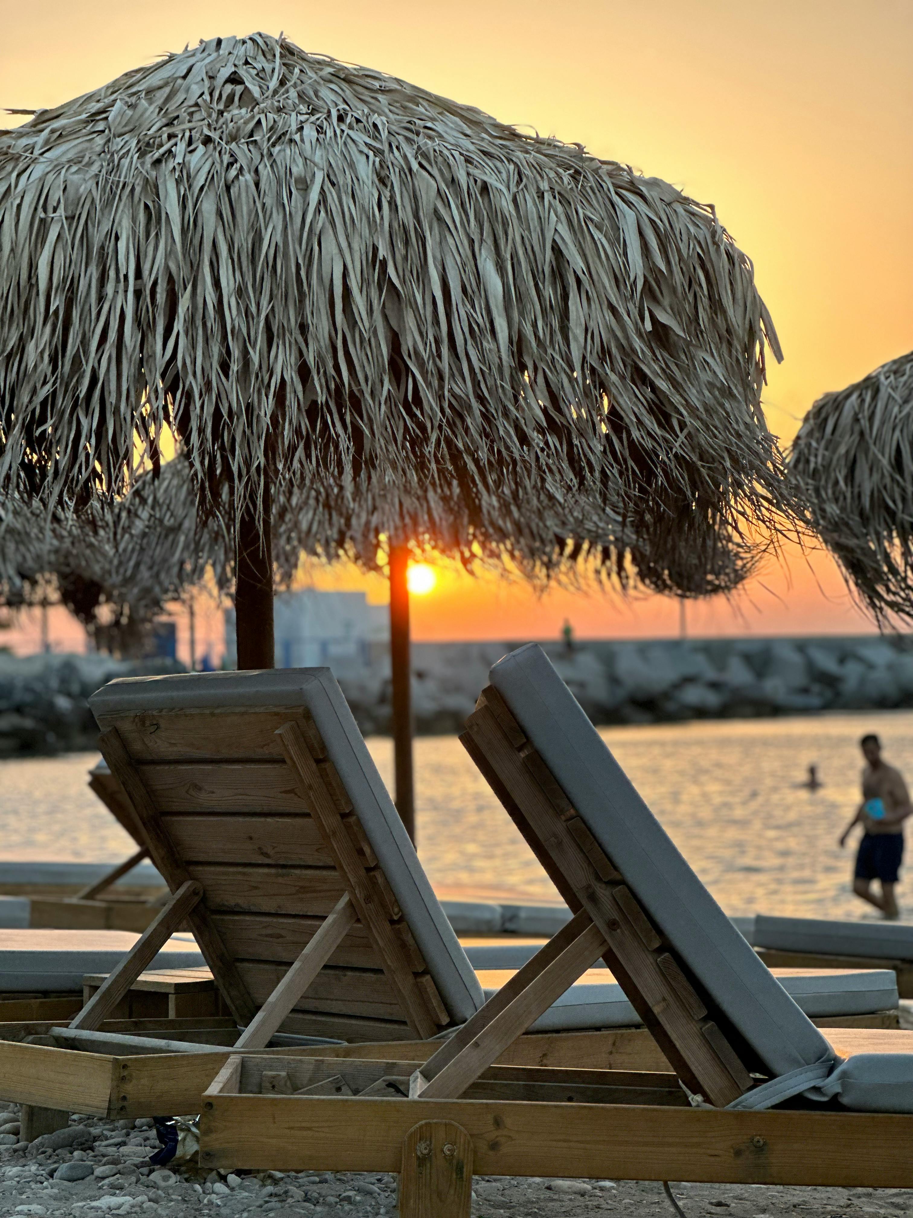 Umbrella and Sunbeds on Sea Shore at Sunset · Free Stock Photo