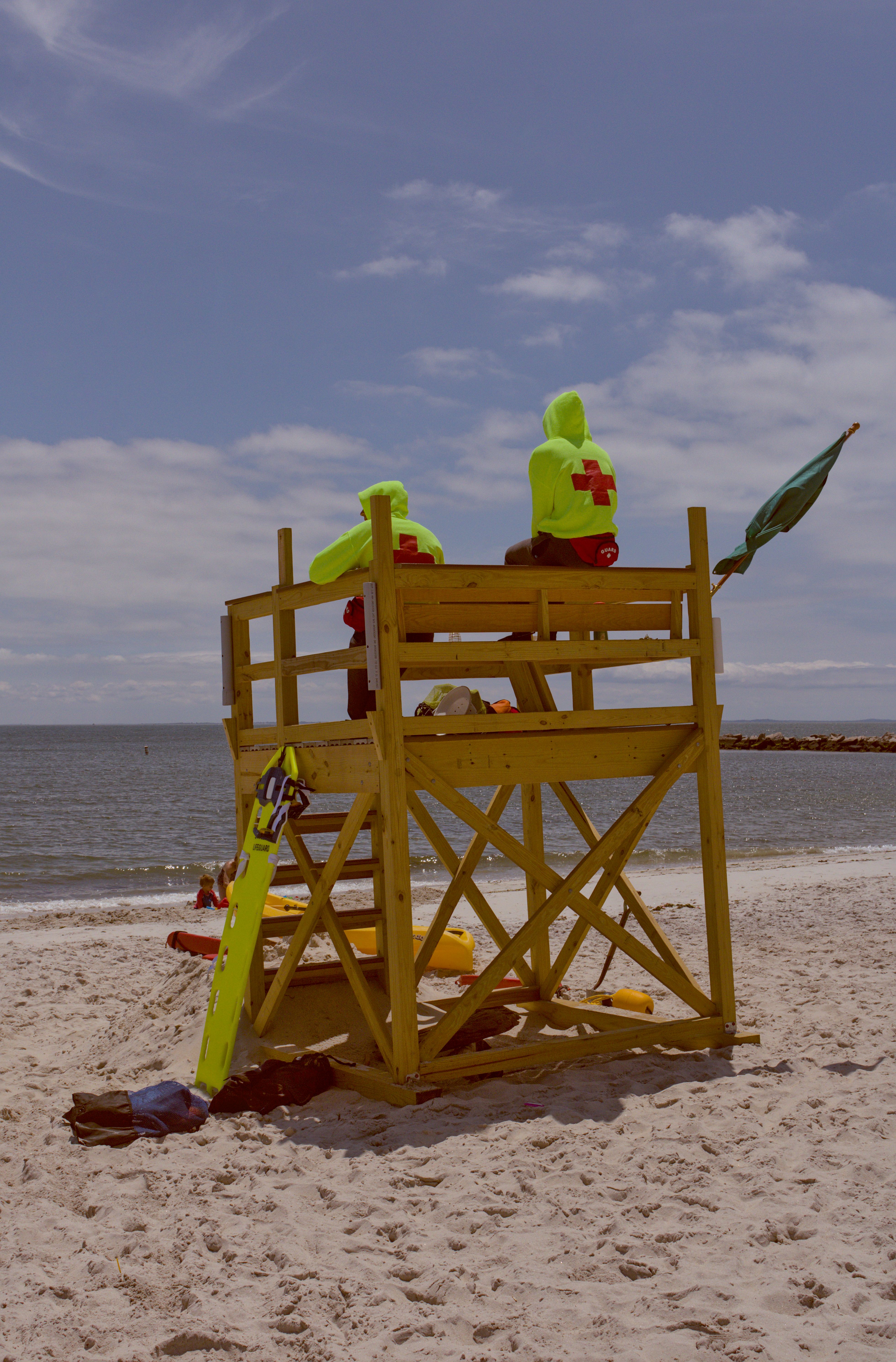 Two people in yellow life jackets on a beach · Free Stock Photo