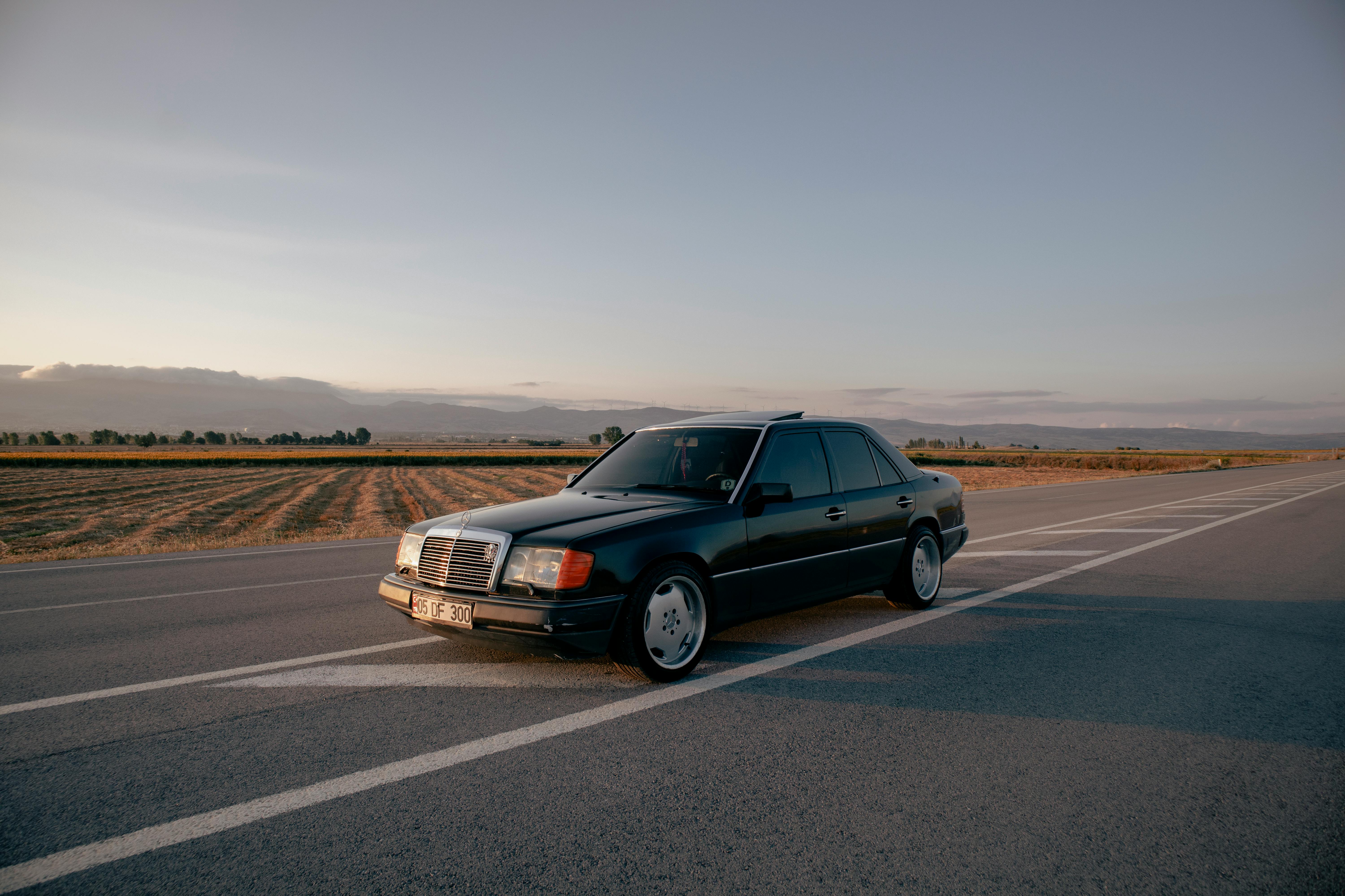 A black mercedes benz car driving on a road · Free Stock Photo