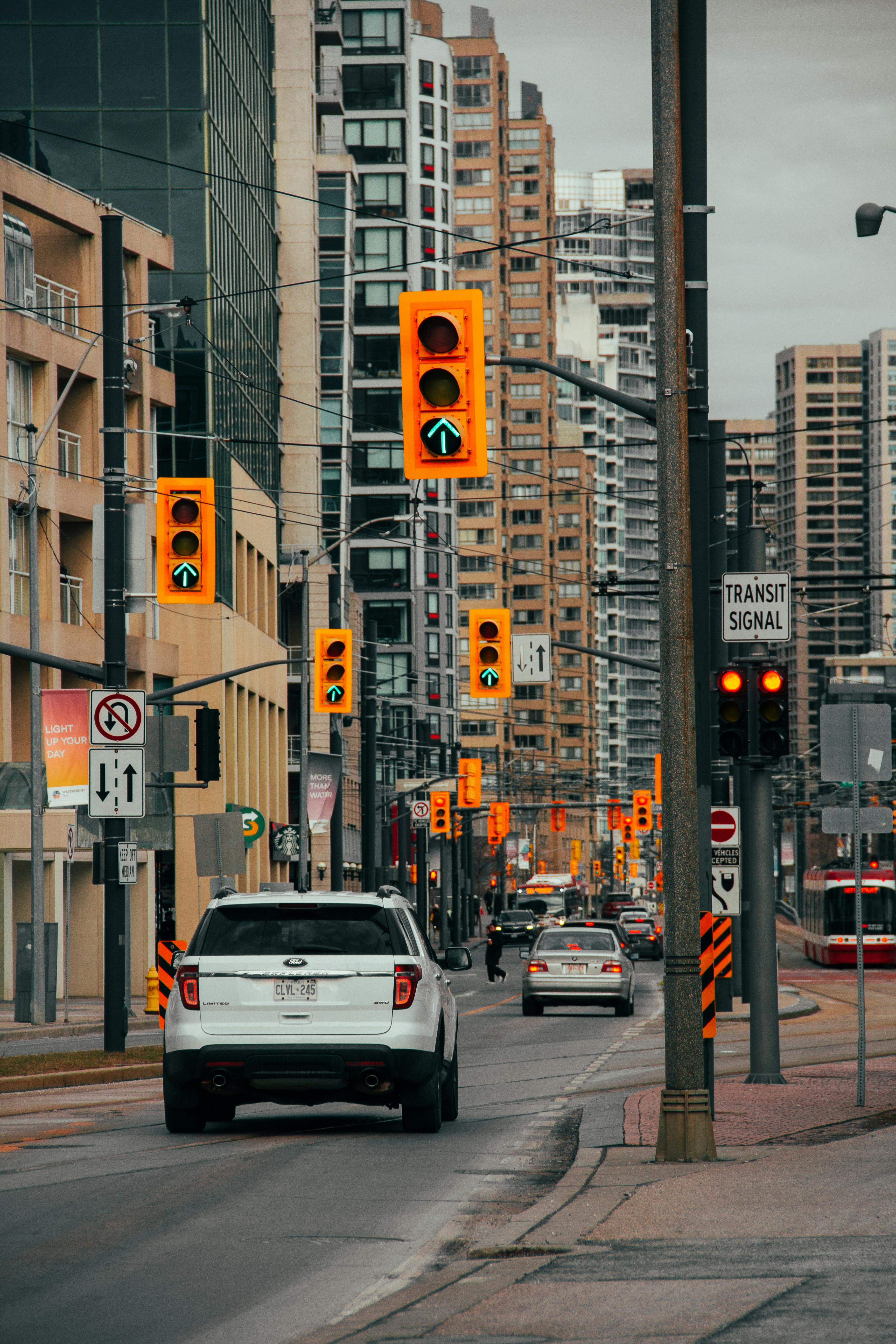 A car driving down a city street with traffic lights · Free Stock Photo