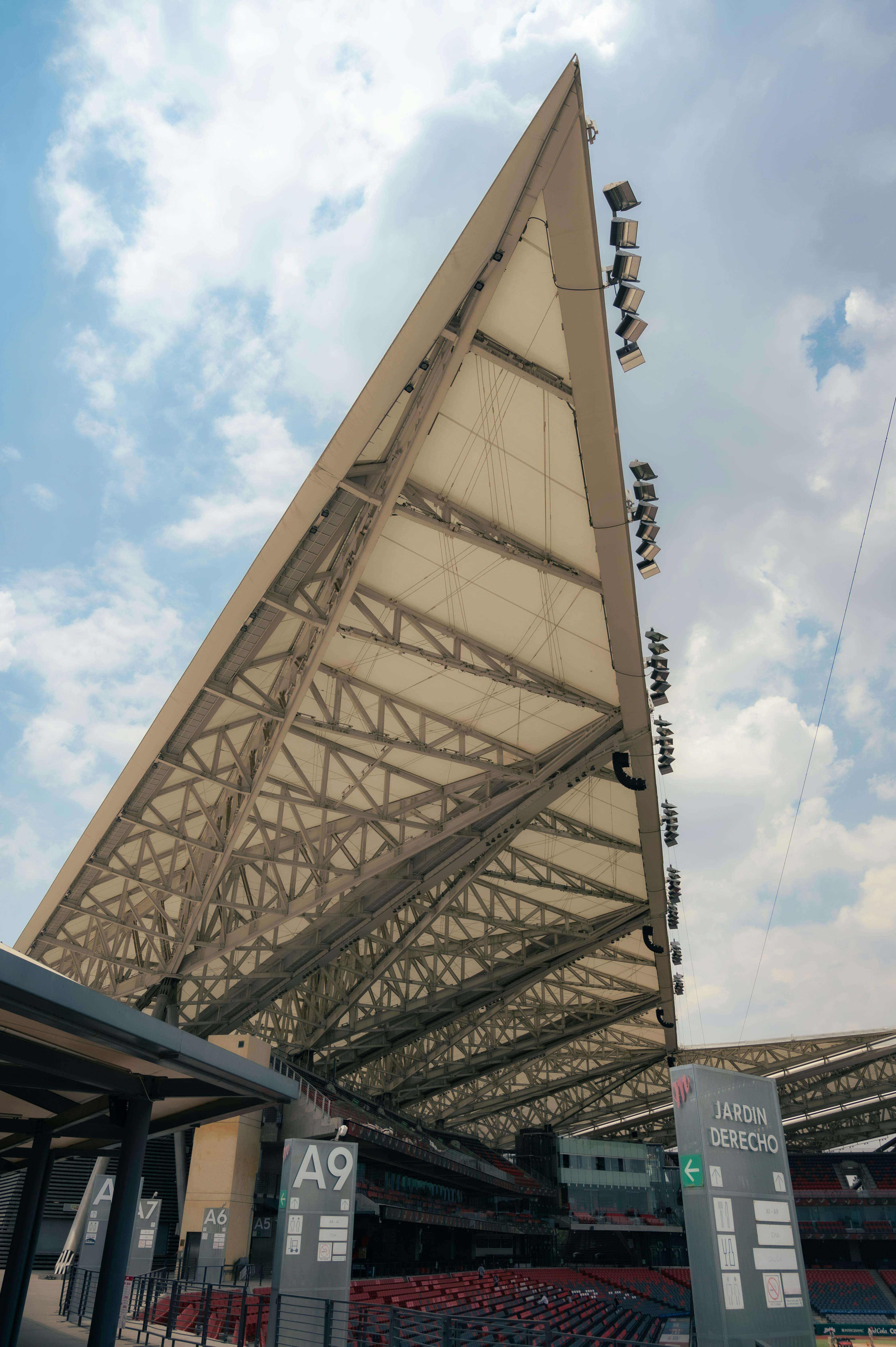 The roof of a stadium with a large metal structure · Free Stock Photo