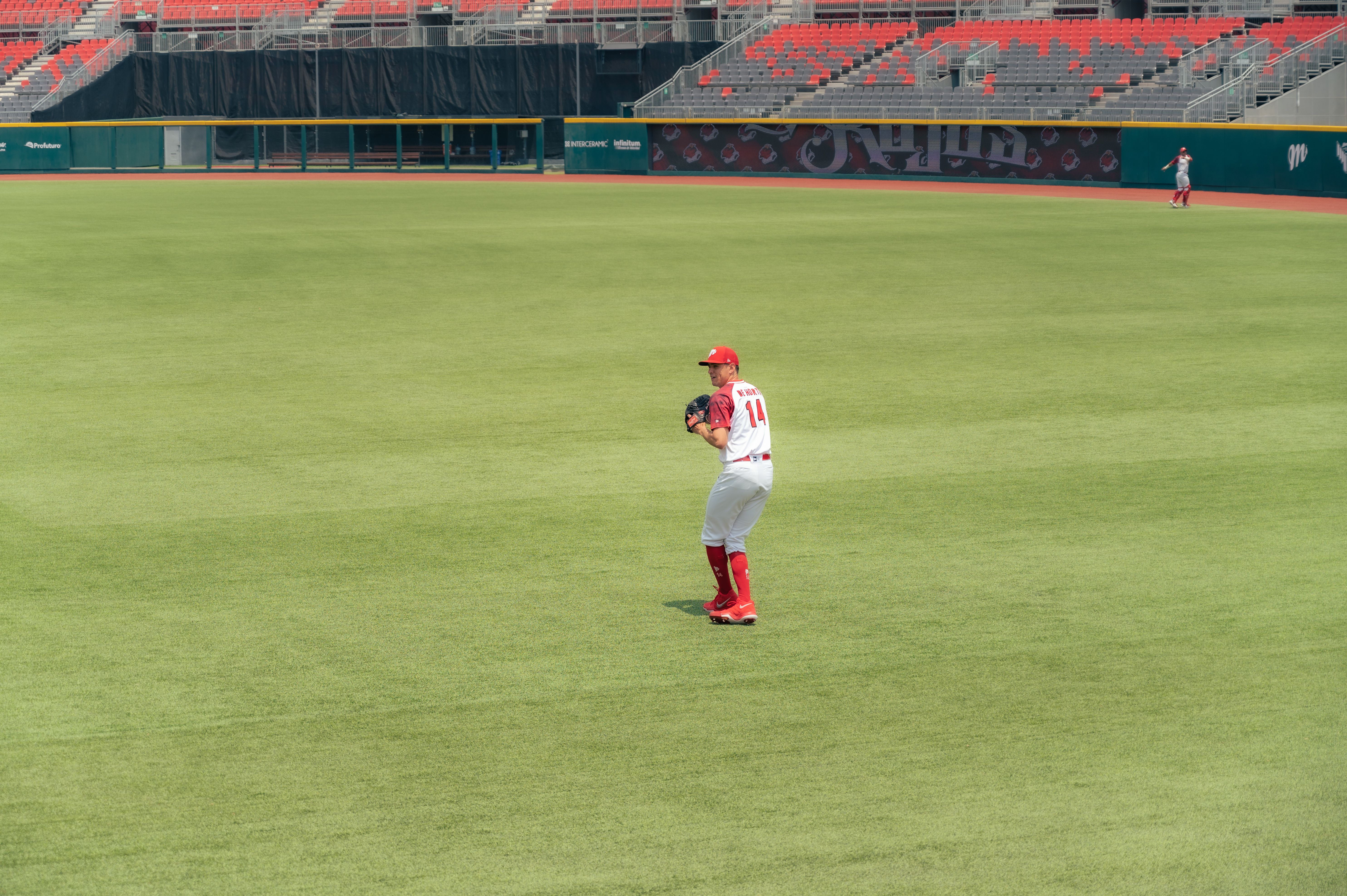 A baseball player is throwing a ball on a field · Free Stock Photo
