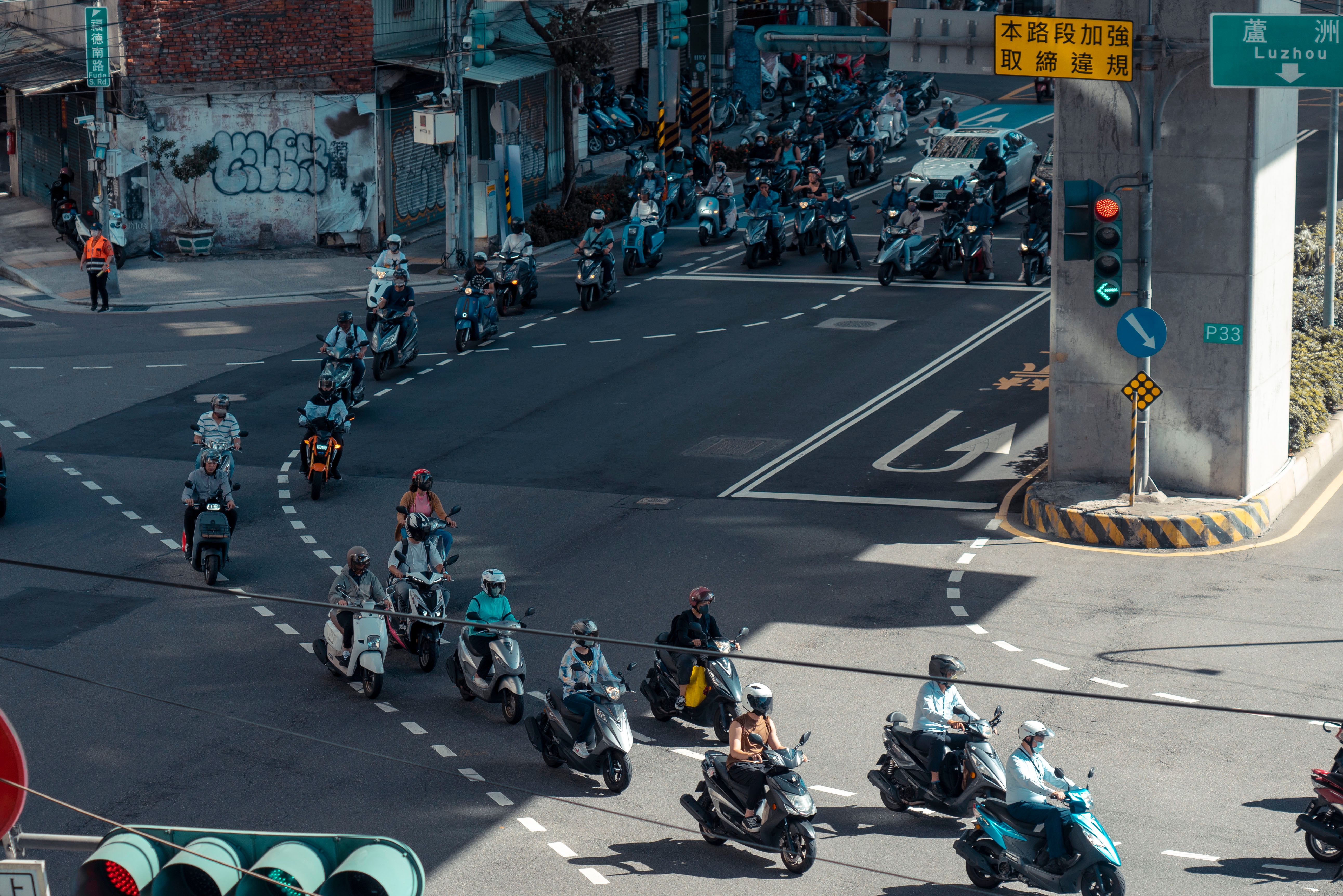 A group of people riding motorcycles on a city street · Free Stock Photo