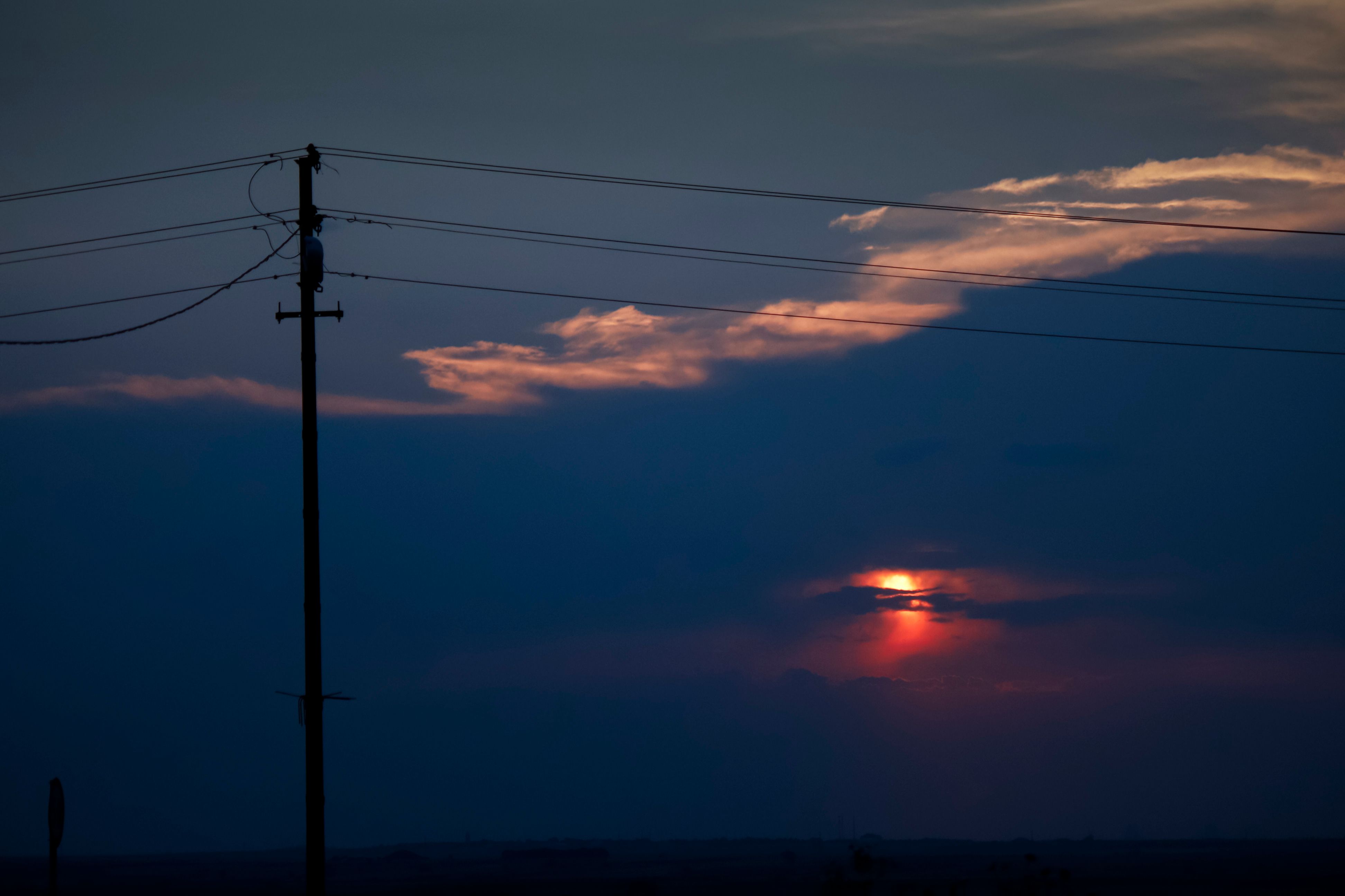 A sunset over a power line and telephone pole · Free Stock Photo