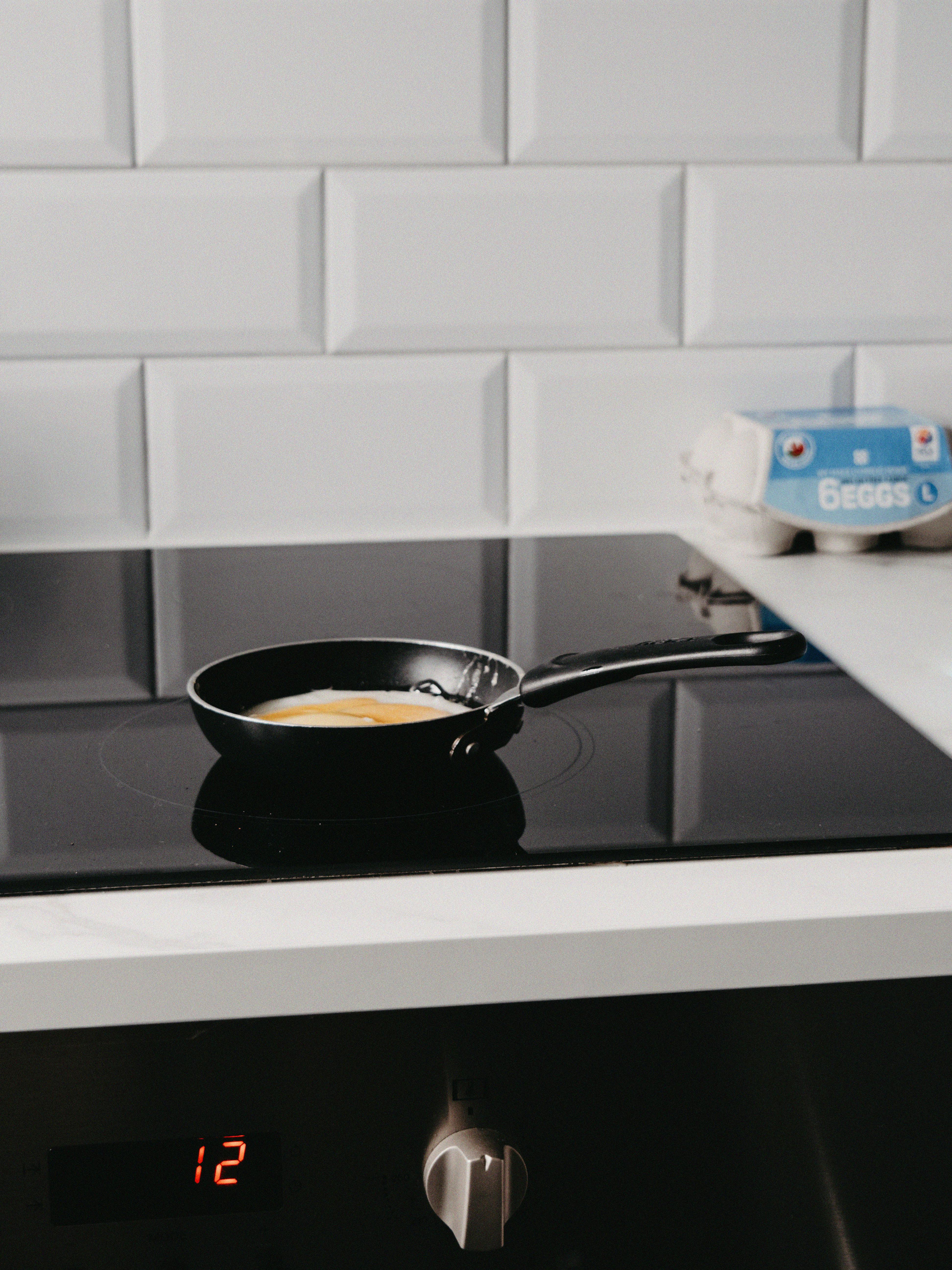 A frying pan on a stove top with a timer · Free Stock Photo