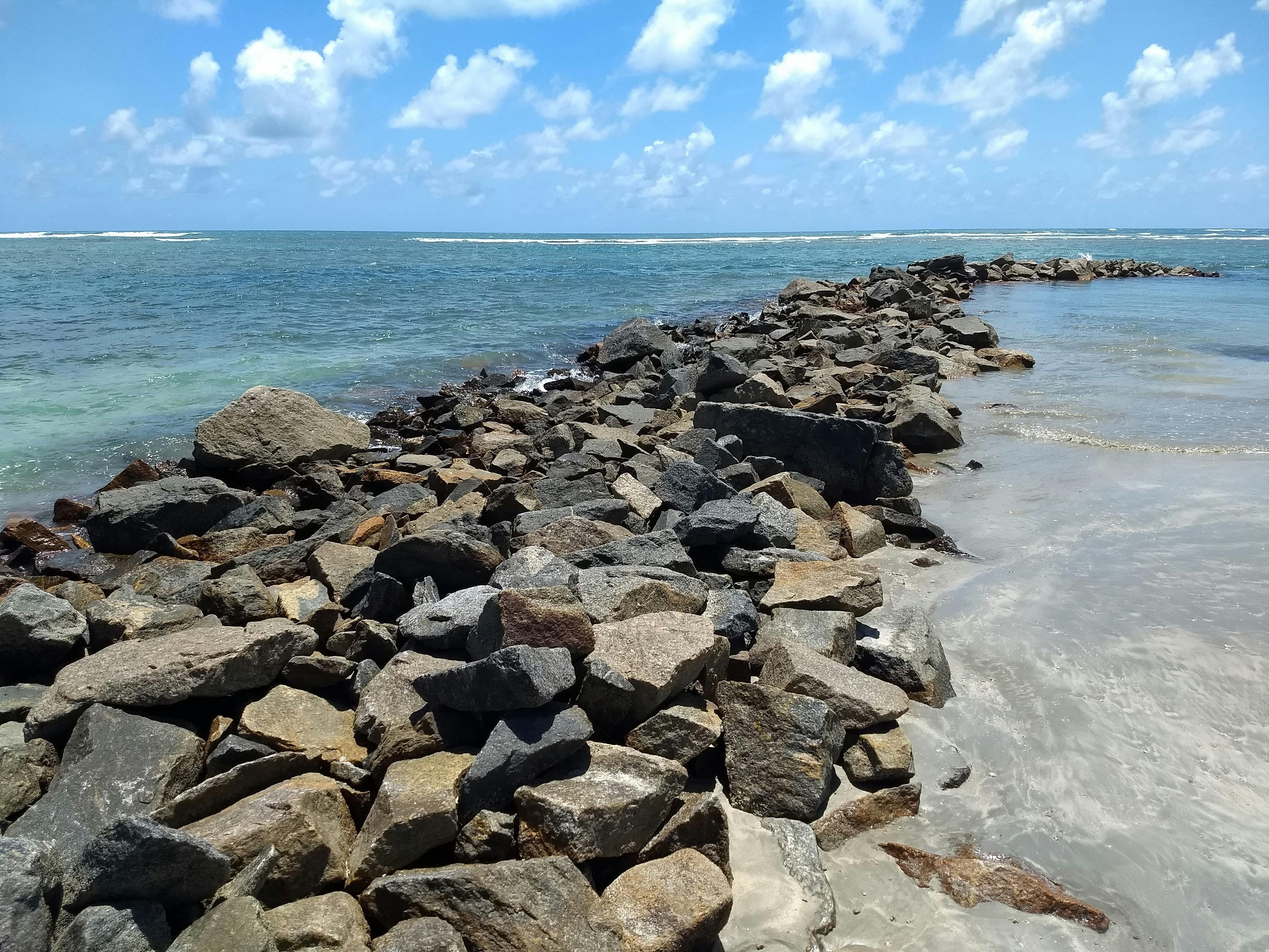 A rocky shoreline with rocks and water · Free Stock Photo