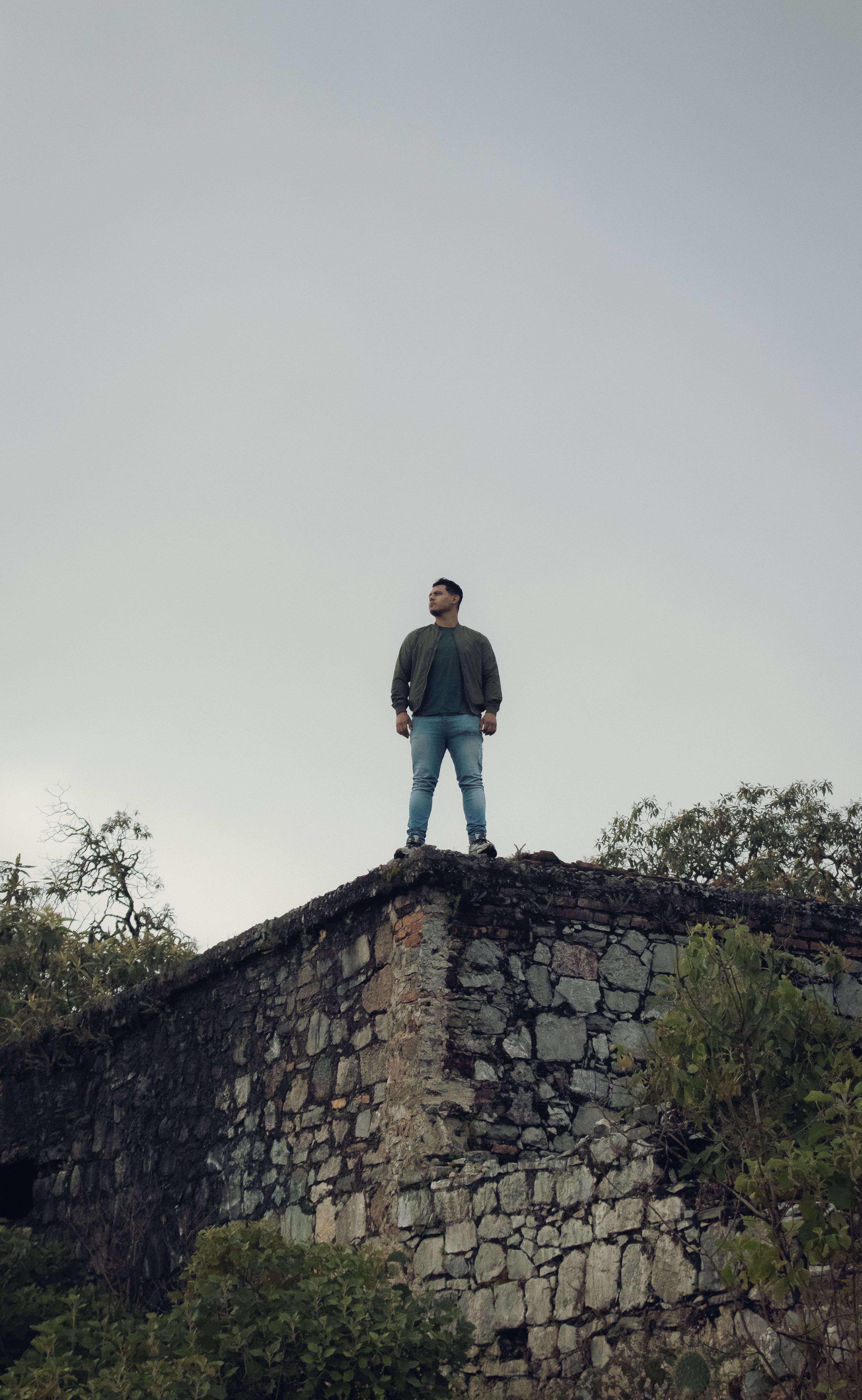 Man Standing on Stone Building Roof · Free Stock Photo
