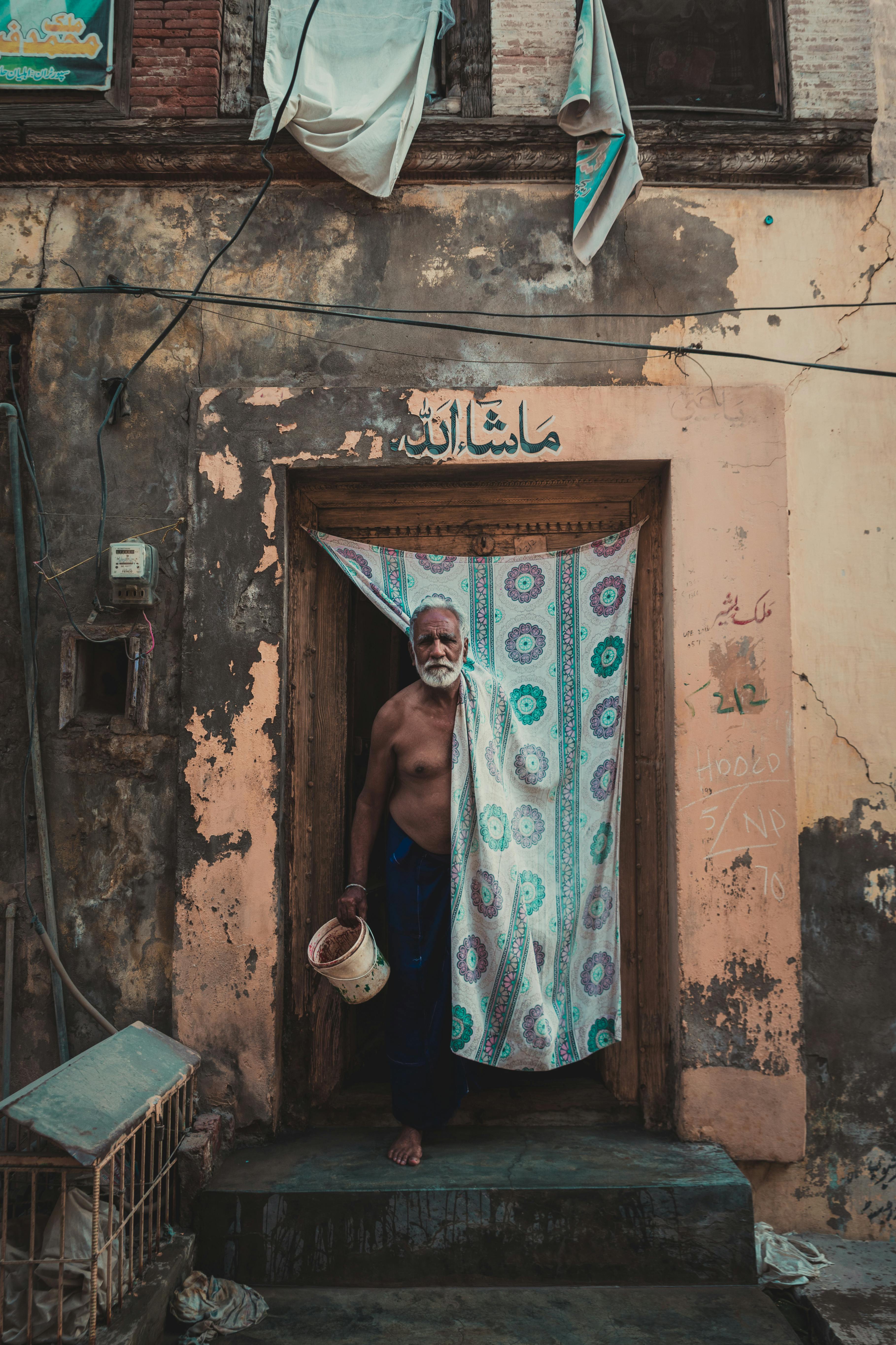 Standing Man Holding Plastic Pail Inside Building · Free Stock Photo