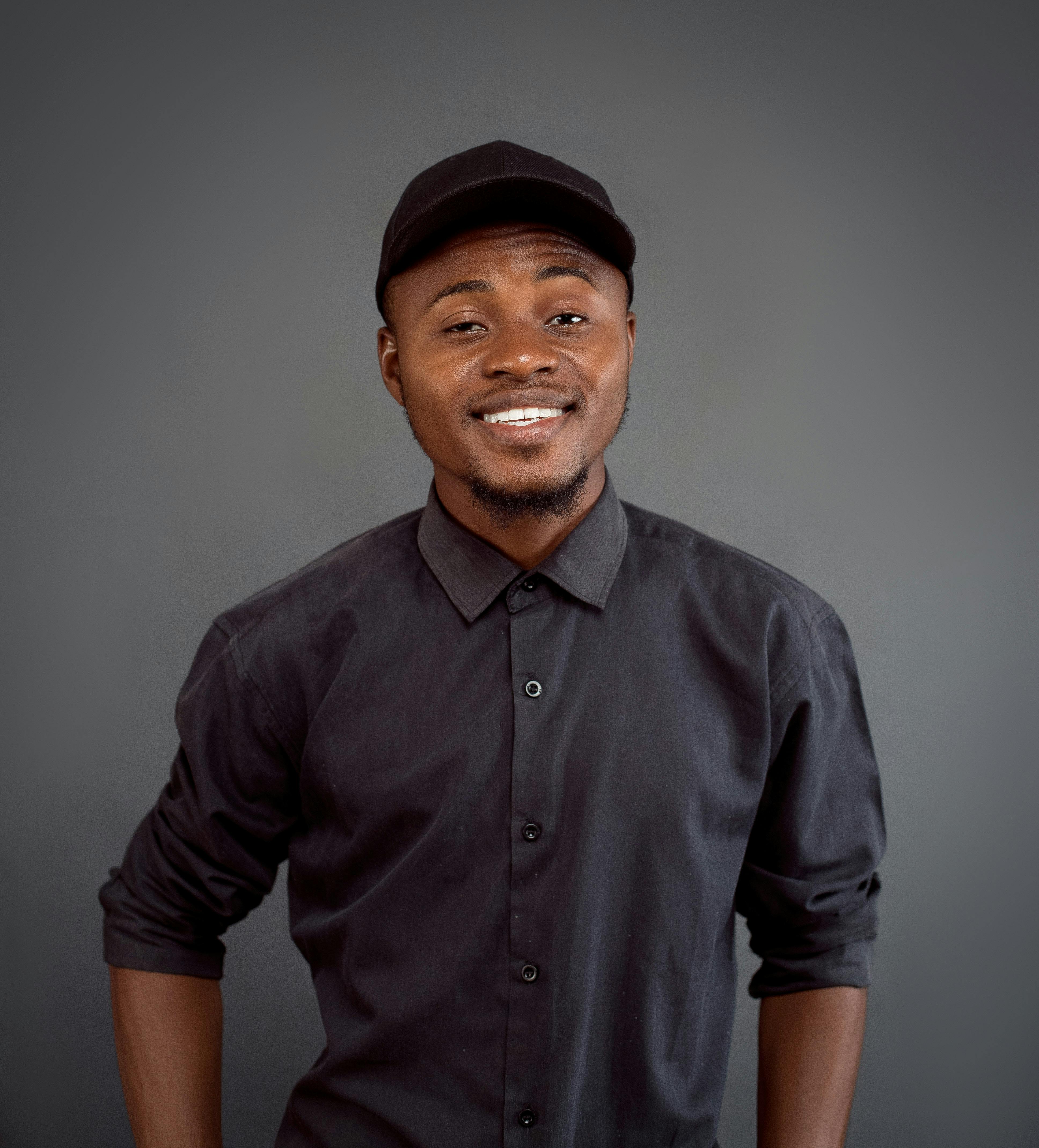 Man wearing black face cap and black shirt smiling · Free Stock Photo