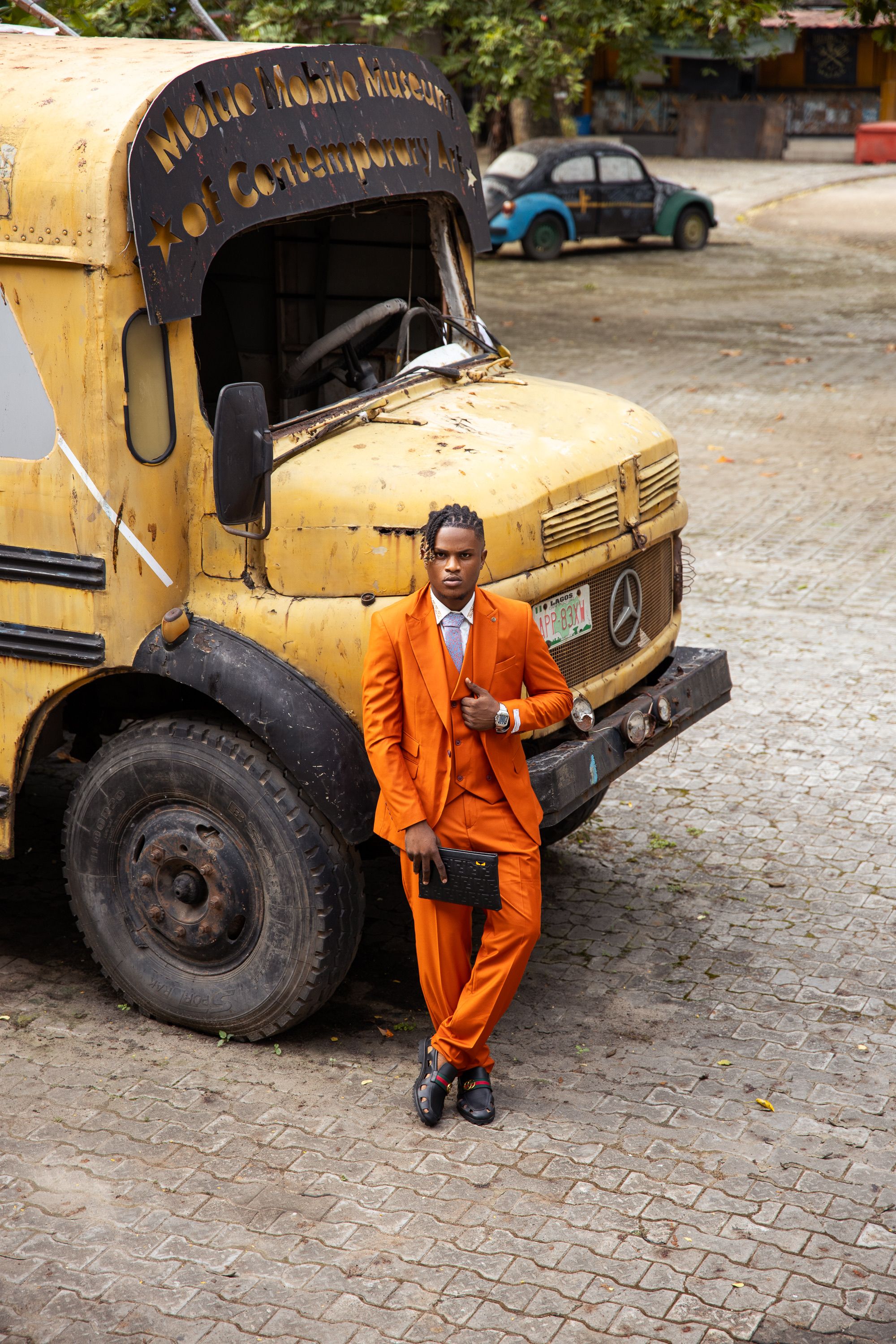 A man in an orange suit standing next to a bus · Free Stock Photo