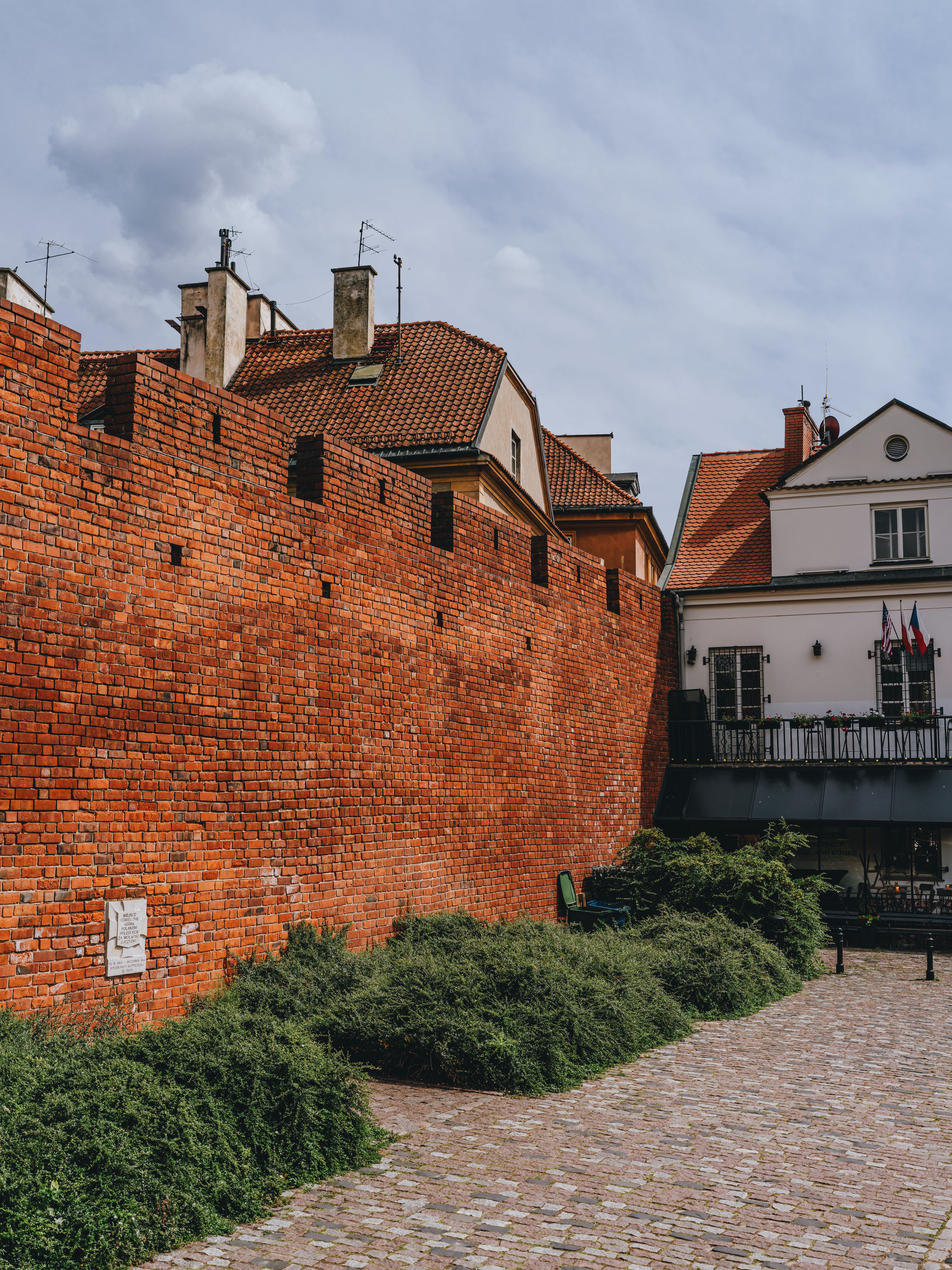Brick Urban Walls with Monument Board in Warsaw · Free Stock Photo