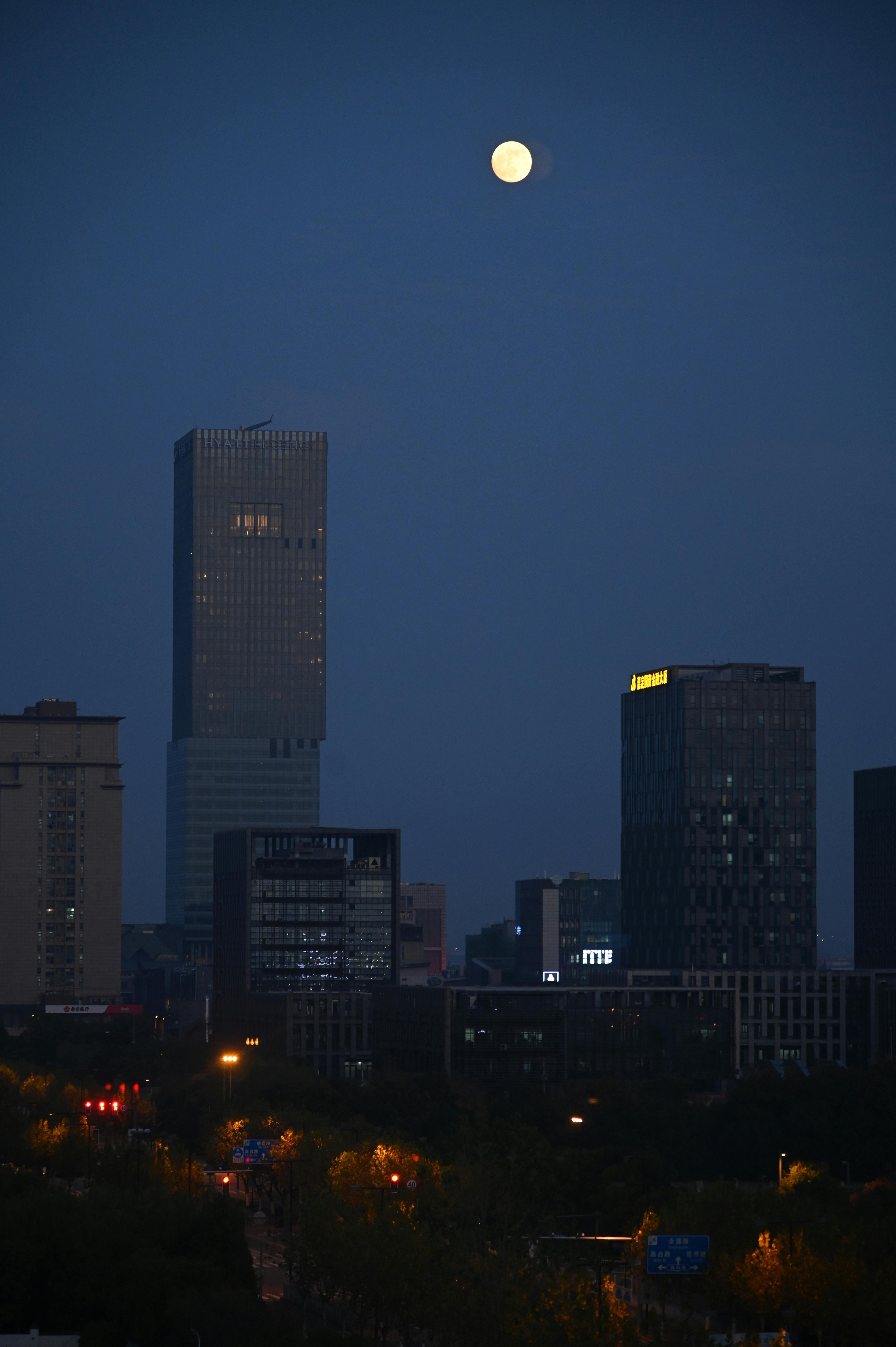 Full Moon over a Night Cityscape with Skyscrapers · Free Stock Photo