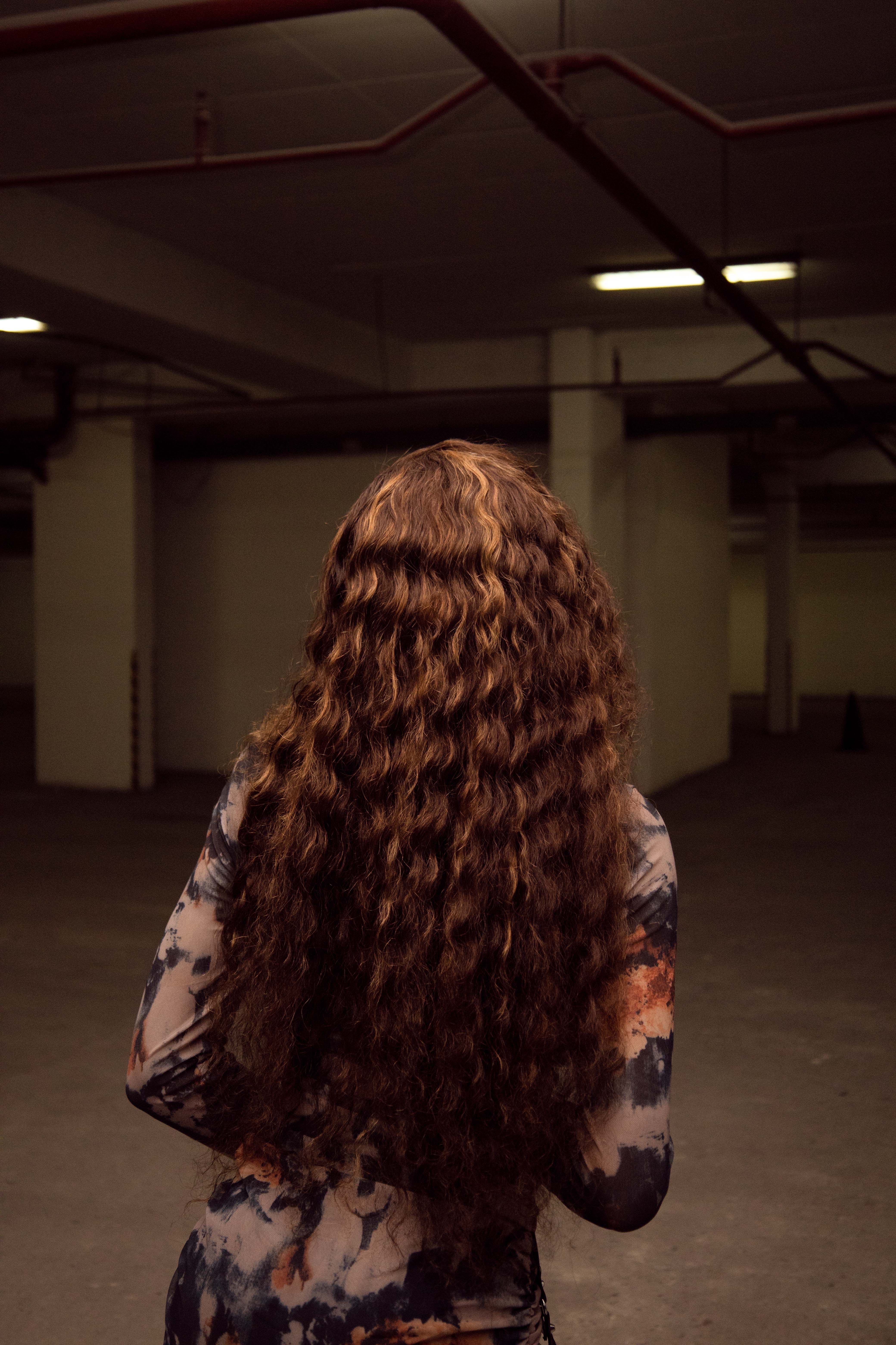Back View of a Woman with Long Wavy Hair · Free Stock Photo