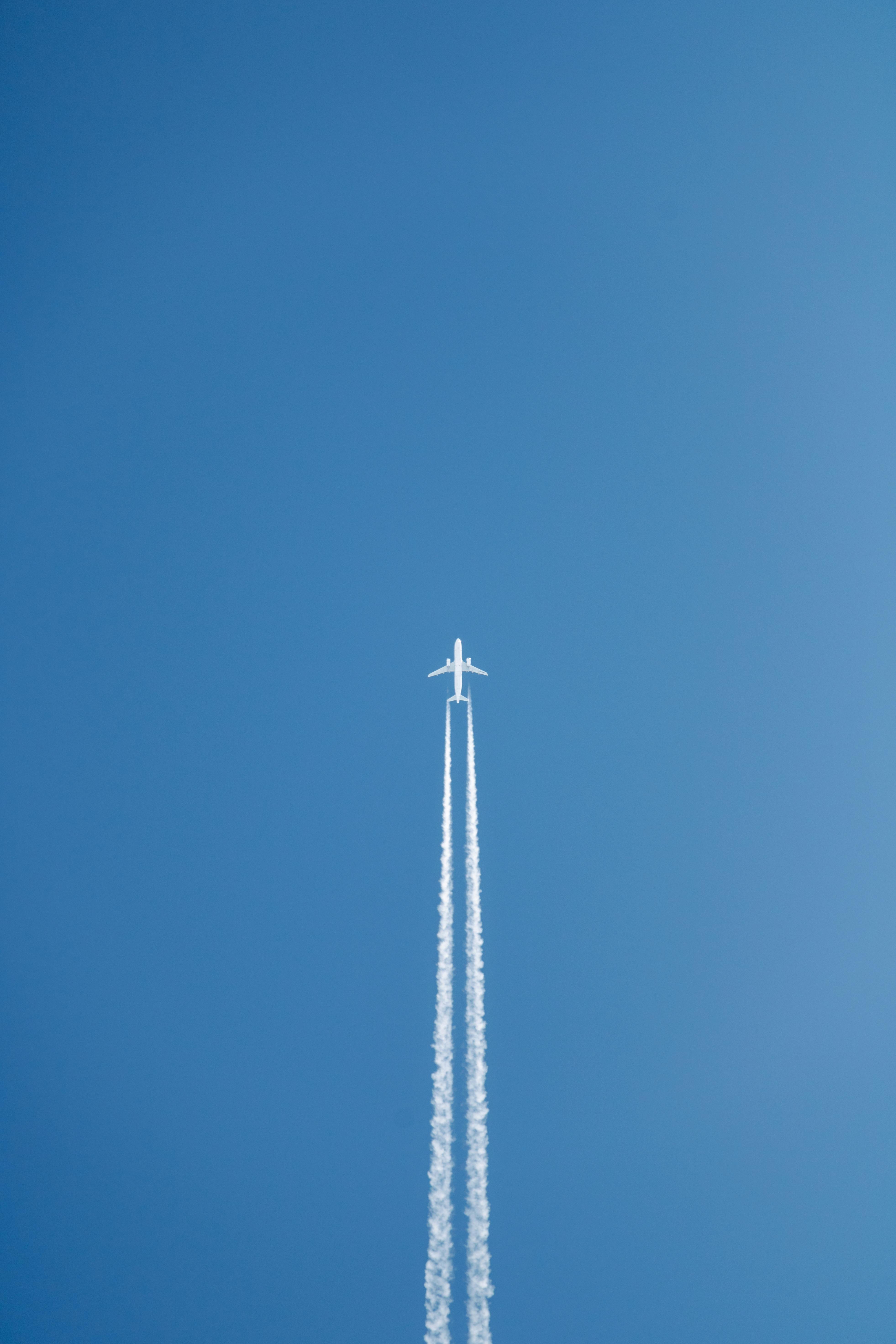 An airplane flying through the blue sky · Free Stock Photo