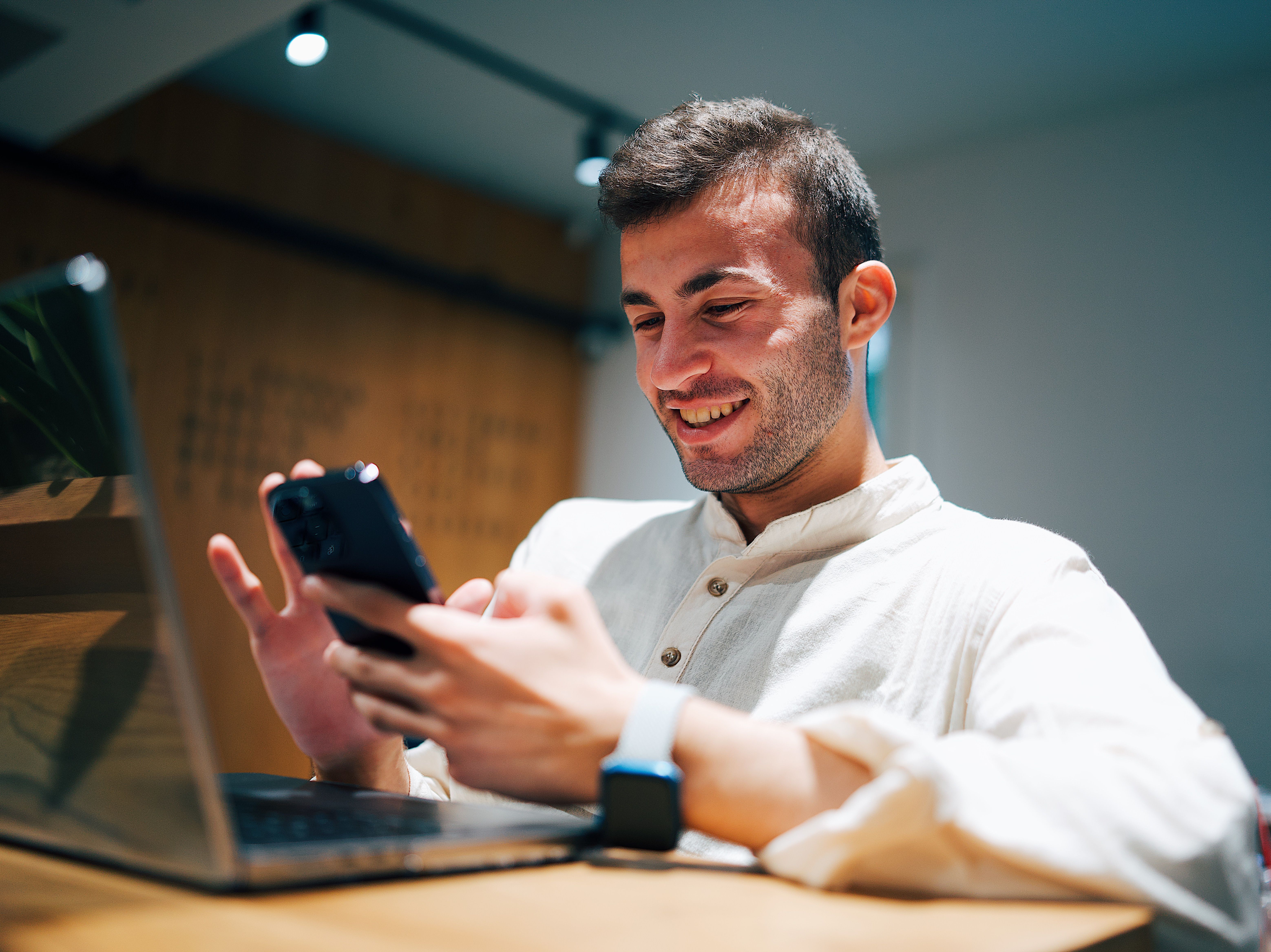 Smiling Man Looking at Smartphone · Free Stock Photo
