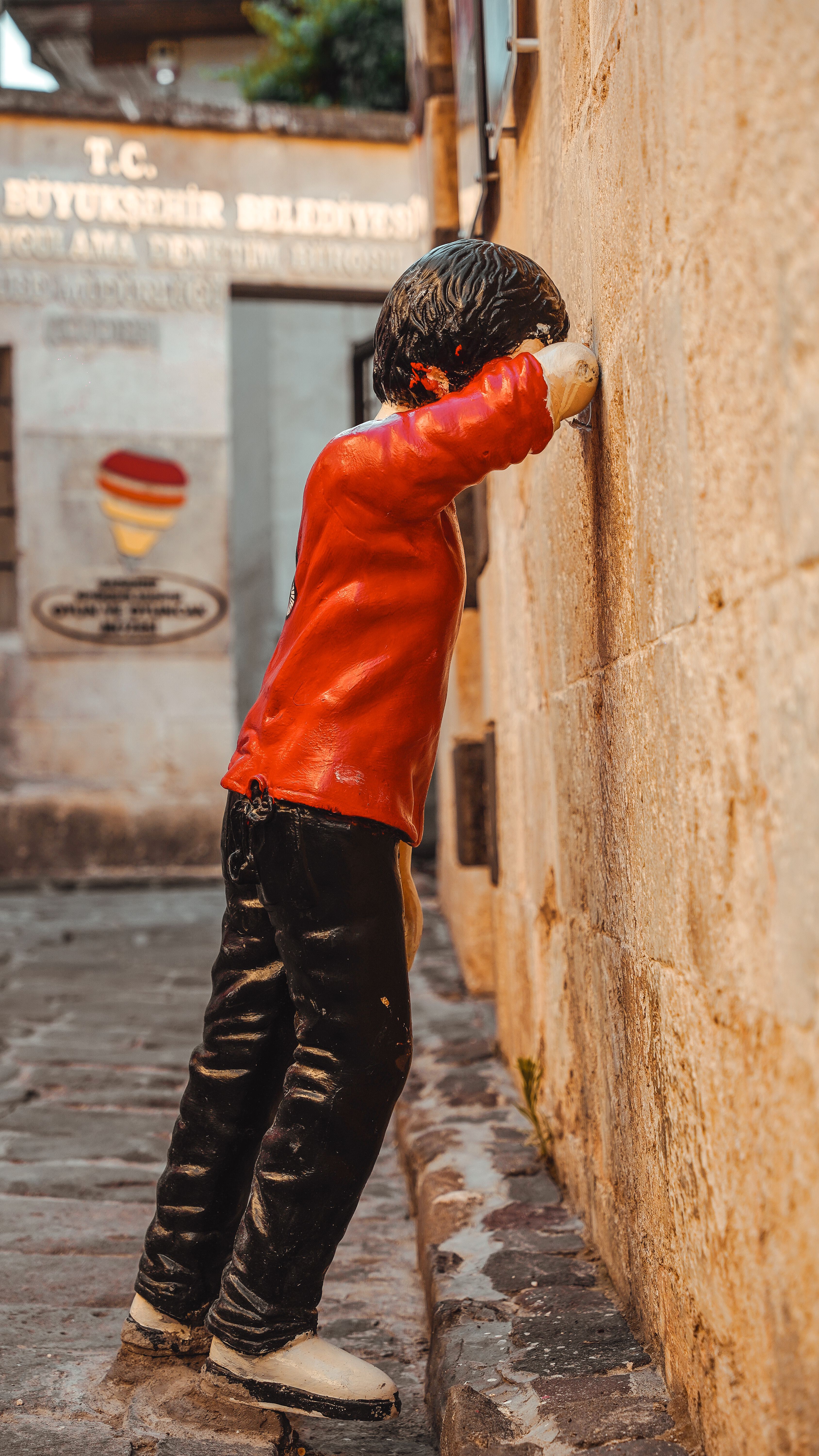 Statue of Boy Standing and Leaning on Wall · Free Stock Photo