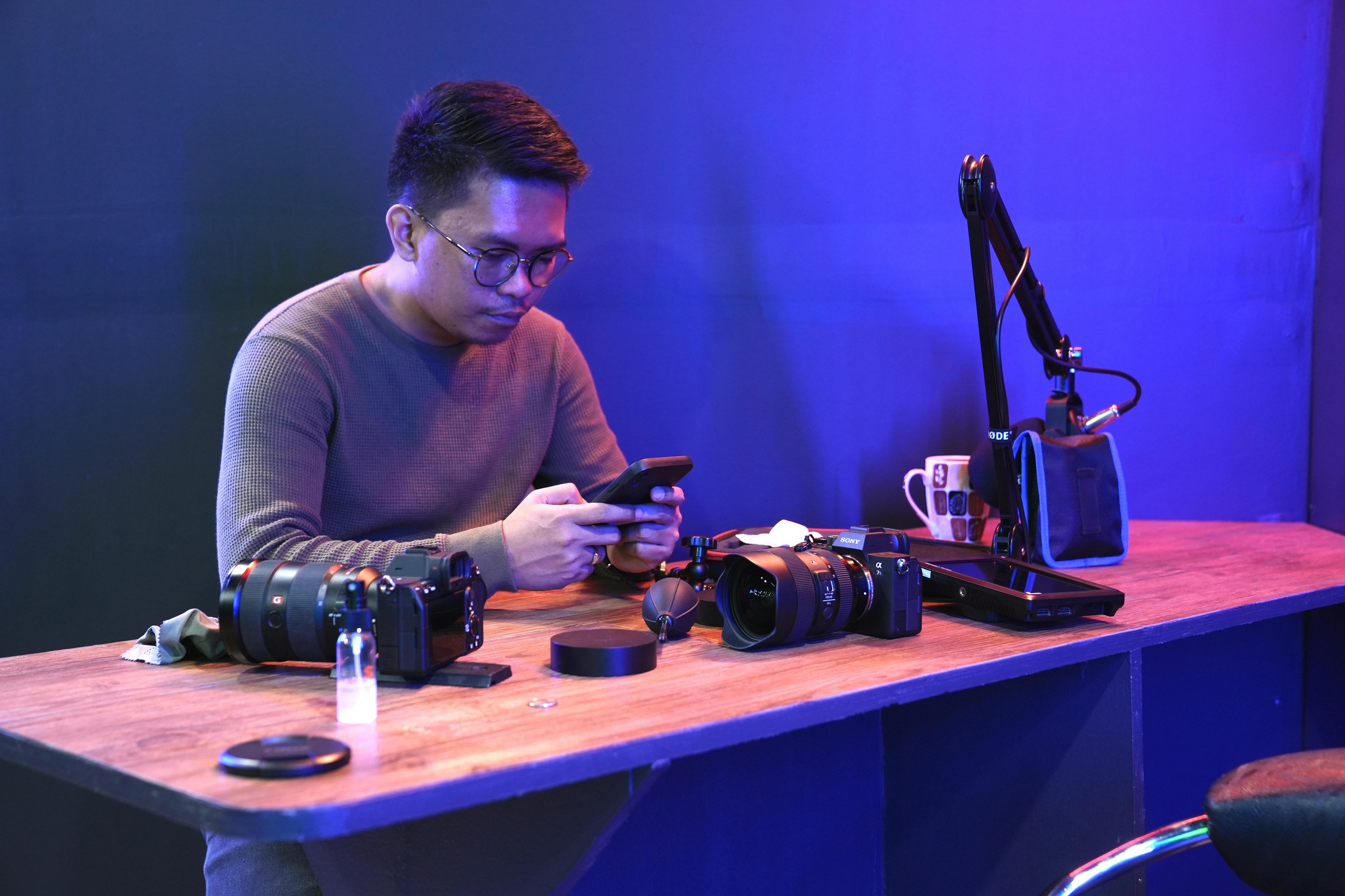 Man Sitting at Table with Photo Equipment · Free Stock Photo